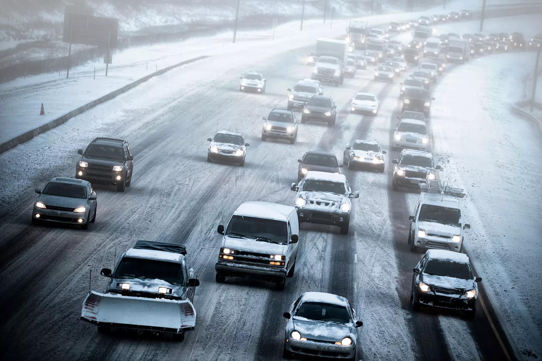 Trácht trom ar mhórbhealaigh oighreata clúdaithe le sneachta.