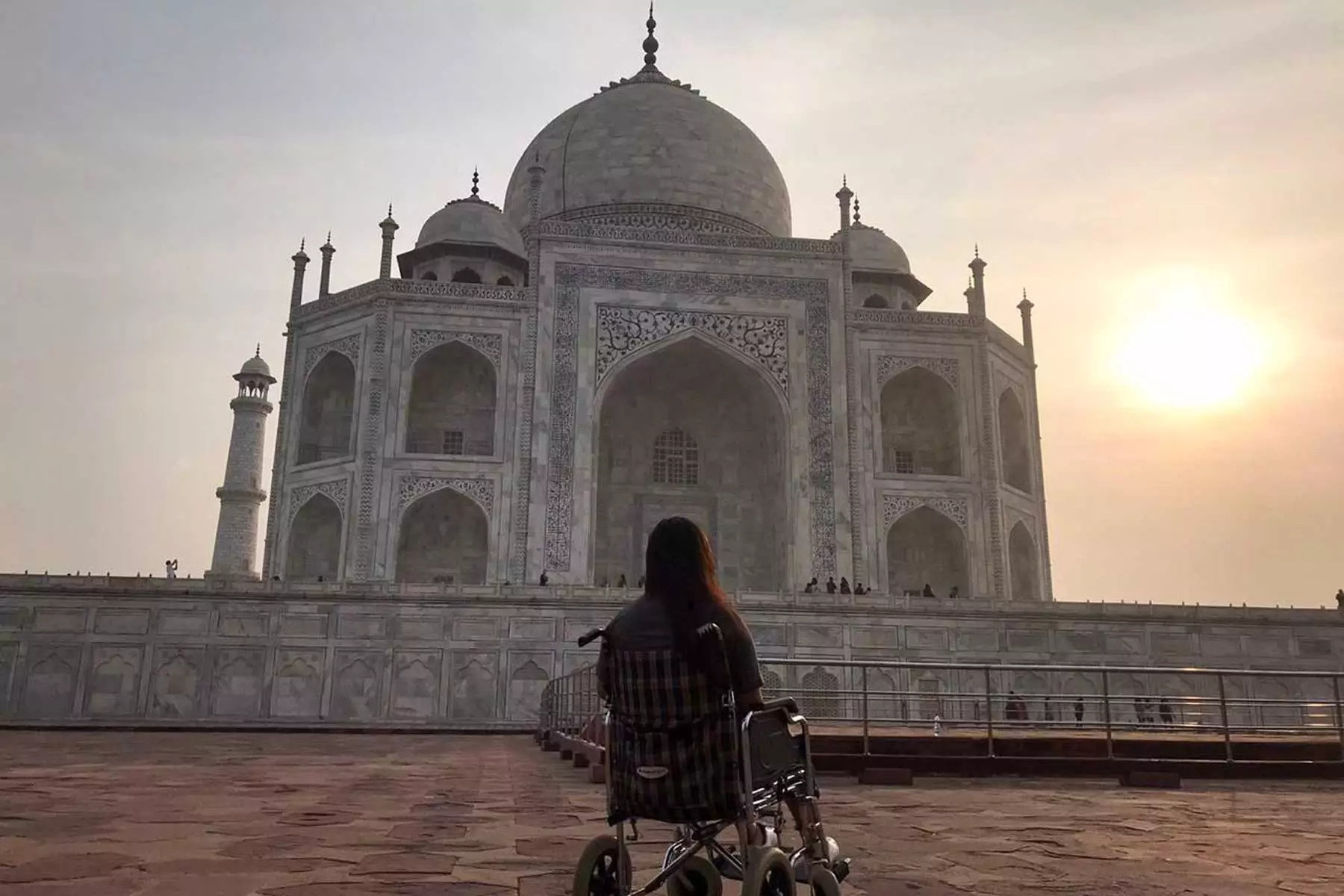 Otu nwanyị nọ n'oche nkwagharị na-ele anya na Taj Mahal