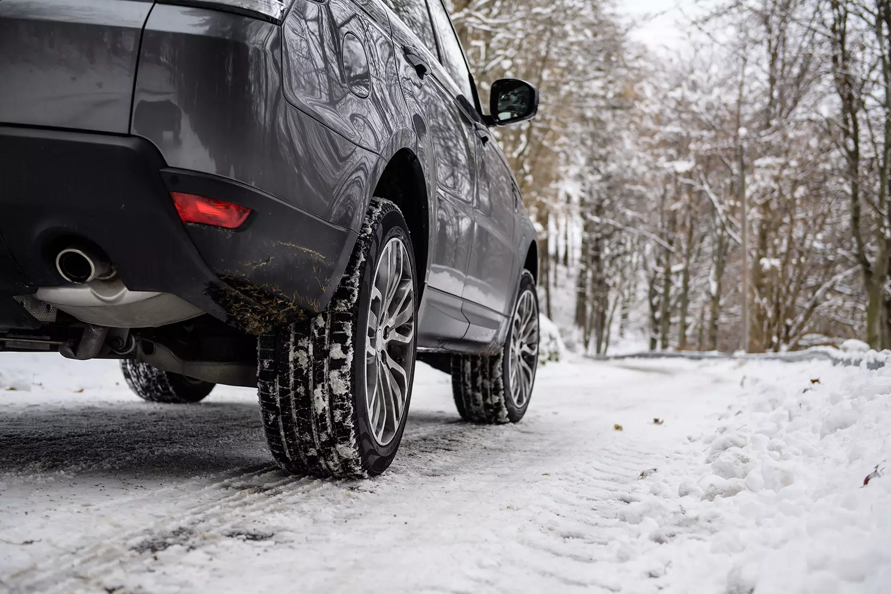 Krupni plan zimskih automobilskih guma postavljenih na sportsko terensko vozilo