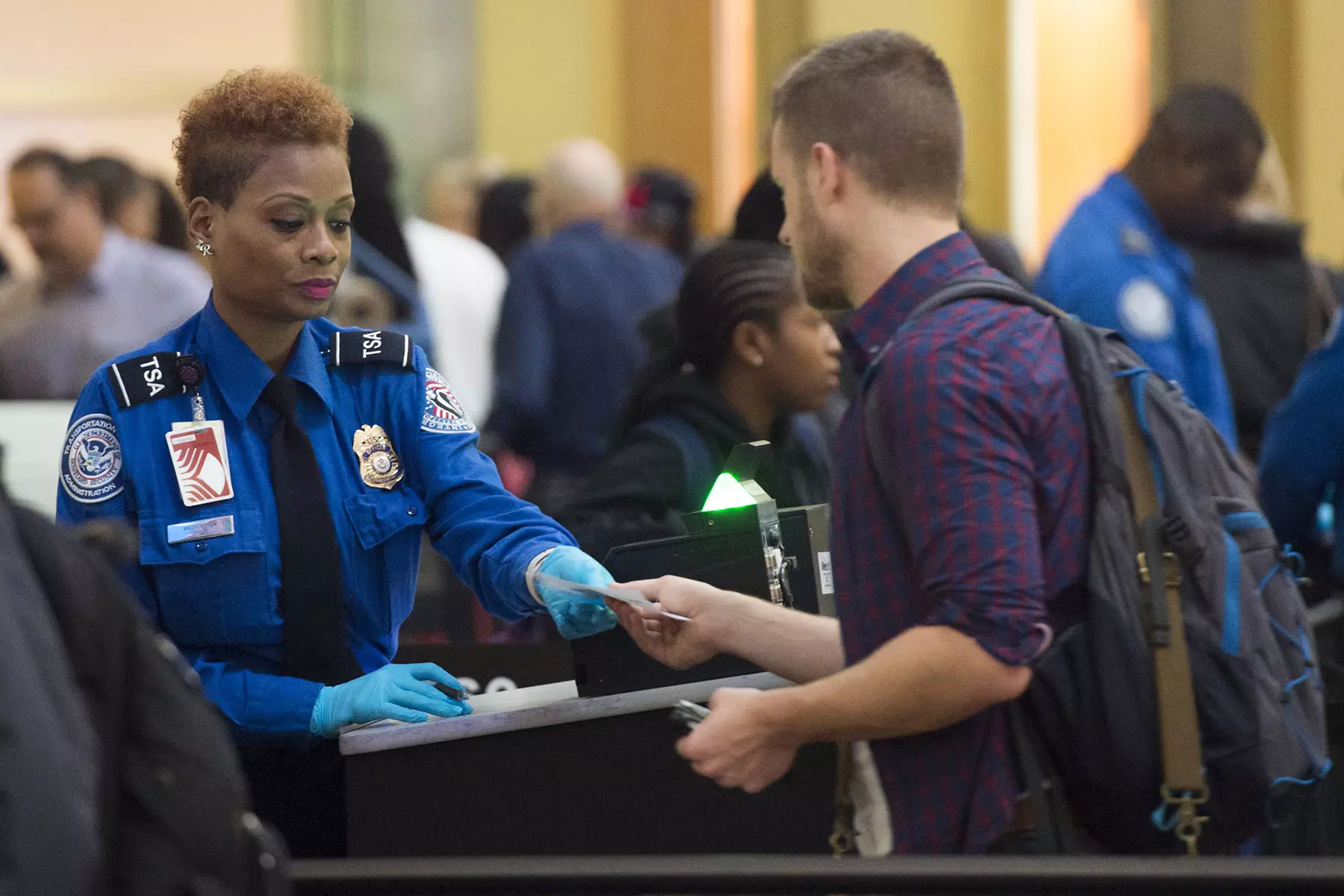 Wakala wa TSA anakagua vitambulisho vya abiria wanapopita kwenye kituo cha ukaguzi cha usalama kwenye njia ya kuelekea safari zao za ndege kwenye Uwanja wa Ndege wa Kitaifa wa Reagan huko Arlington, Virginia.