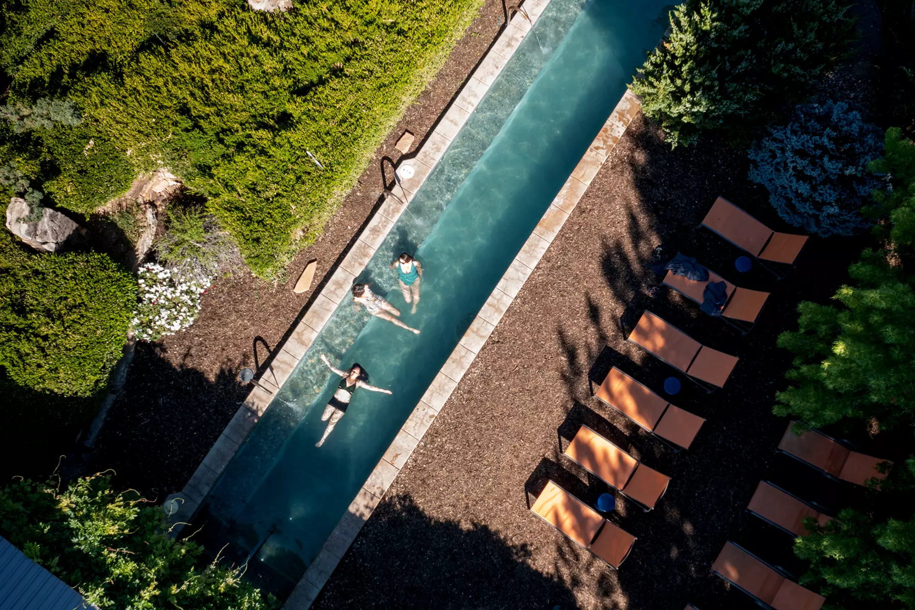 Trois personnes nagent dans la piscine du spa Ojo Santa Fe