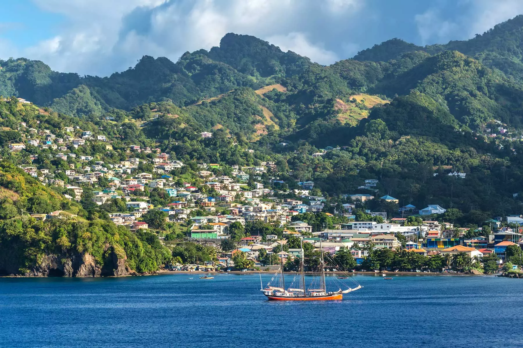 Tanawin ng baybayin ng daungan at lungsod ng Kingstown, kabisera ng isla ng Caribbean na Saint Vincent. Naglalayag na barko sa harapan.