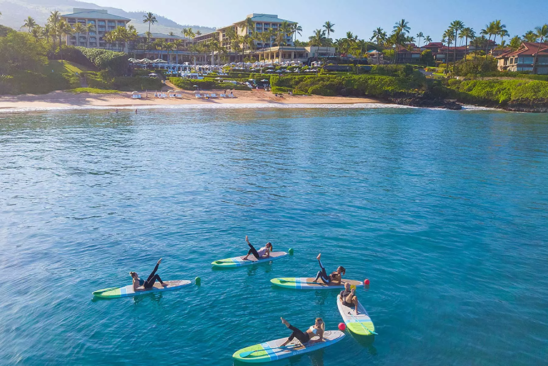 Una lezione di fitness HIIT su tavole da paddle al Four Seasons Maui