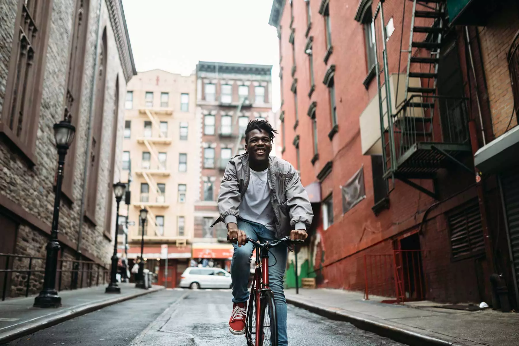 Saurang pamuda Afrika Amérika ngajalajah China Town di New York City nganggo sapedah anu tetep.