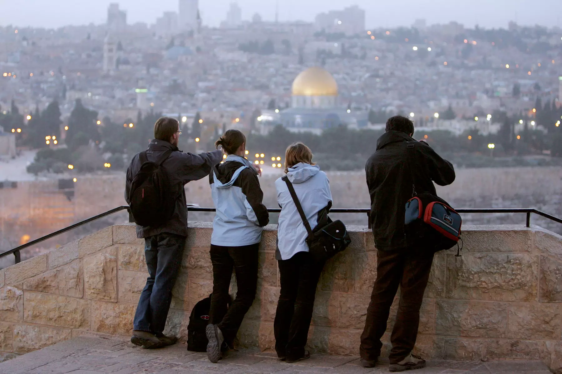 Turistid seisavad Oliivide mäel, kui õhtu langeb üle Iisraeli Jeruusalemma vanalinna.