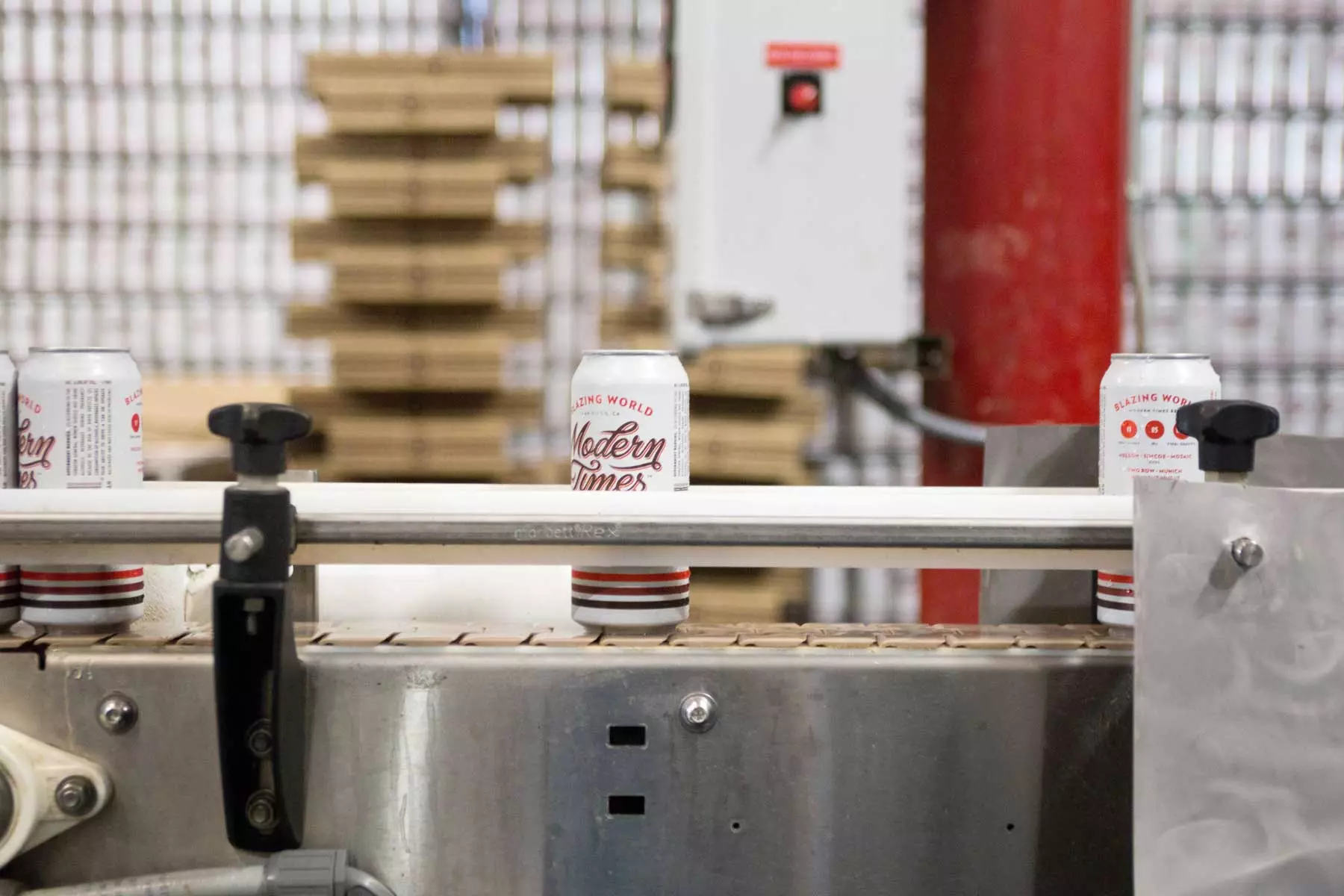 Latas de cervexa na liña de produción da cervexaría Modern Times en San Diego