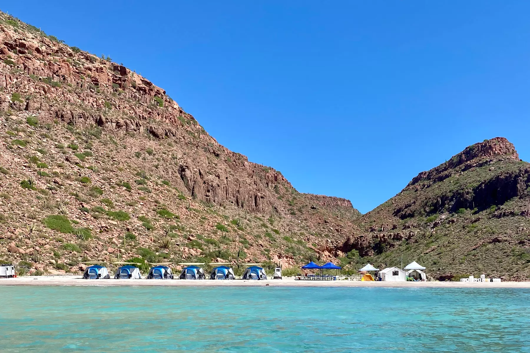 Glamping strand sátrakkal és szörfdeszkákkal a vízről nézve