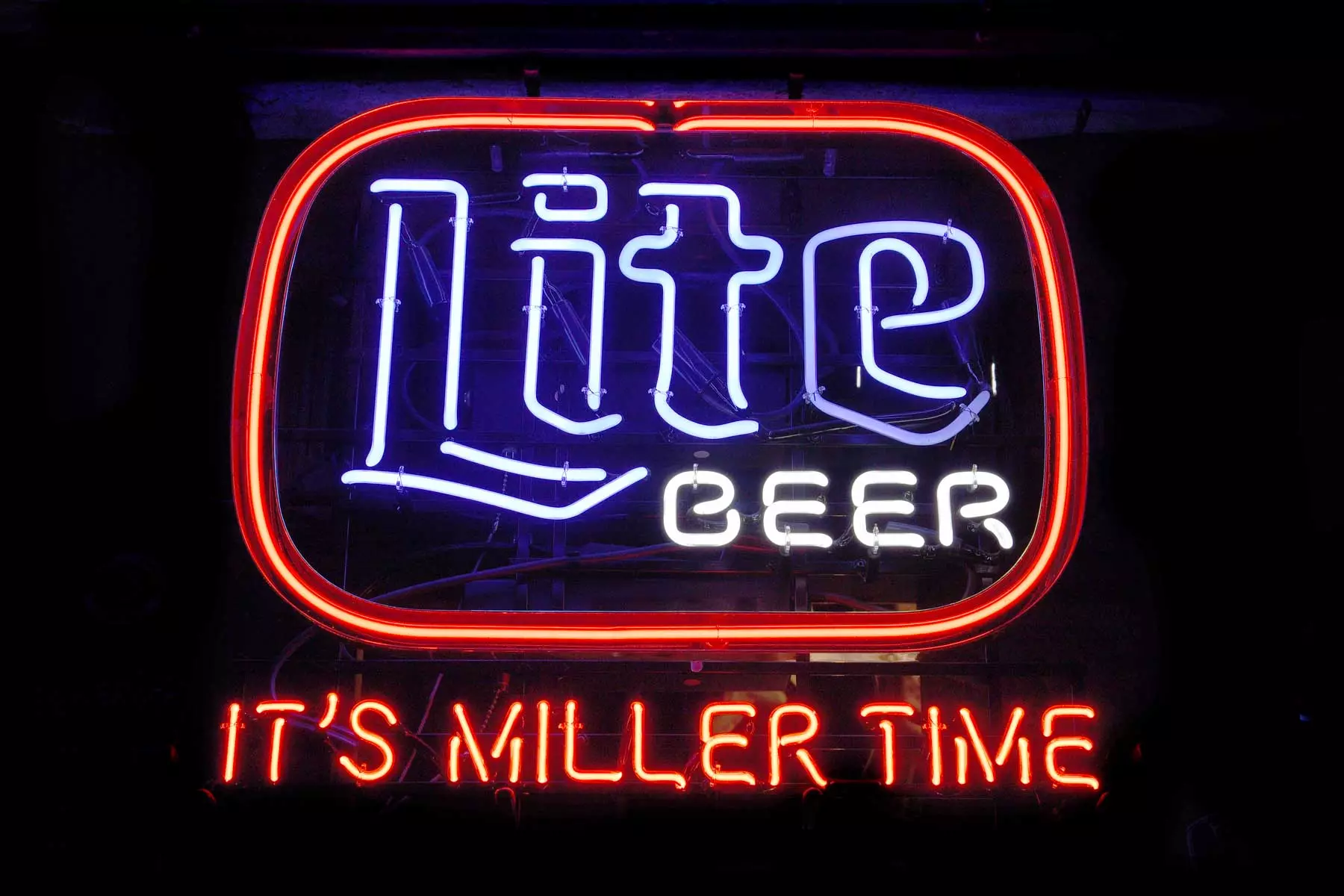 Um sinal de néon anunciando a cerveja Miller Lite queima na loja geral e bar em Luckenbach, Texas, uma comunidade não incorporada perto de Fredericksburg, Texas