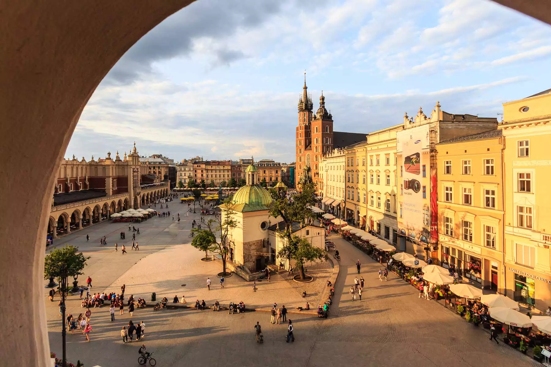 Vue duerch eng archway op eng ëffentlech Plaz zu Krakau, Polen, gewielt eng vun de beschte Stied op der Welt