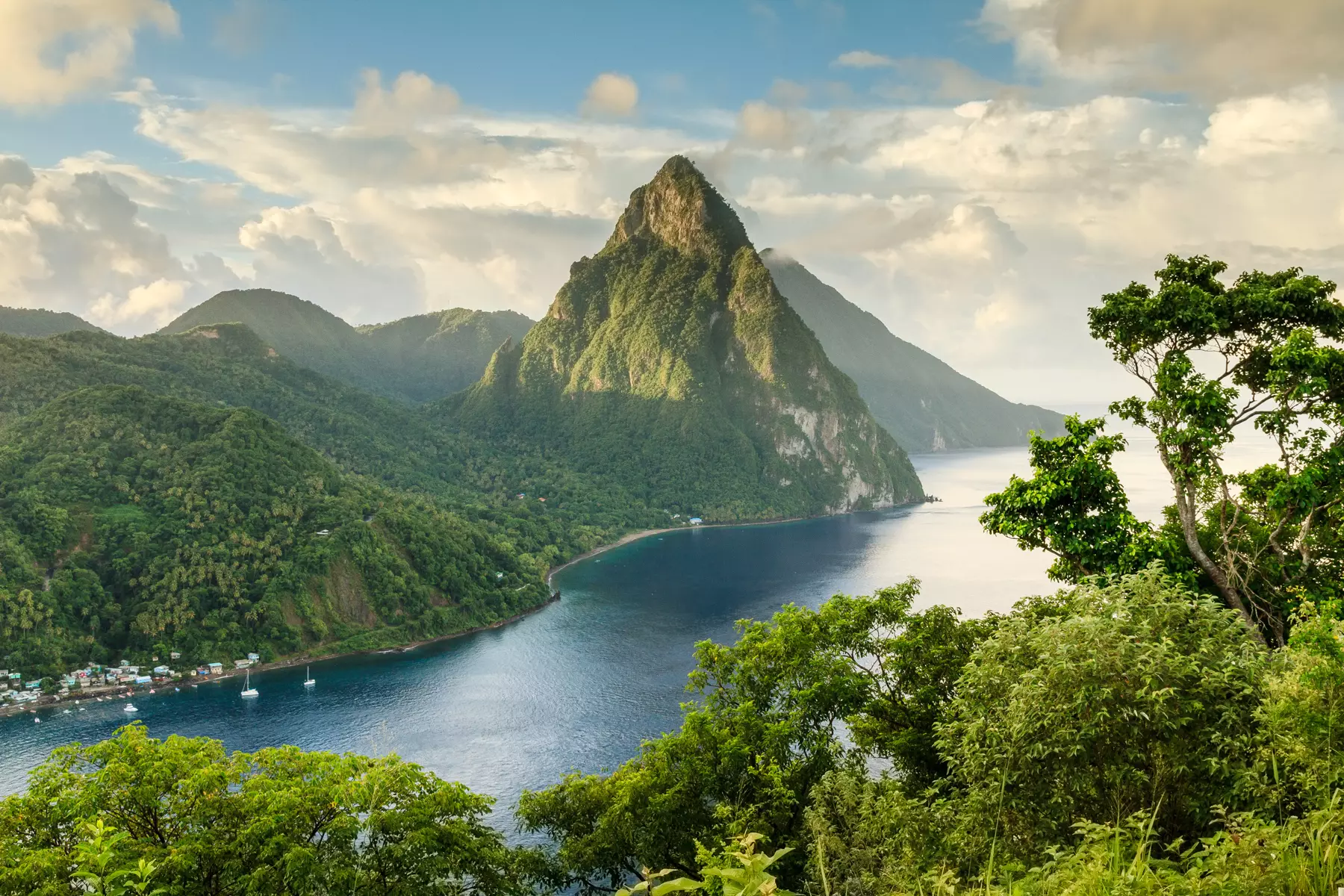 Vista do Petit Piton e Gros Piton de Santa Lúcia de um ponto de vista elevado com a floresta tropical e a baía de Soufrière em primeiro plano