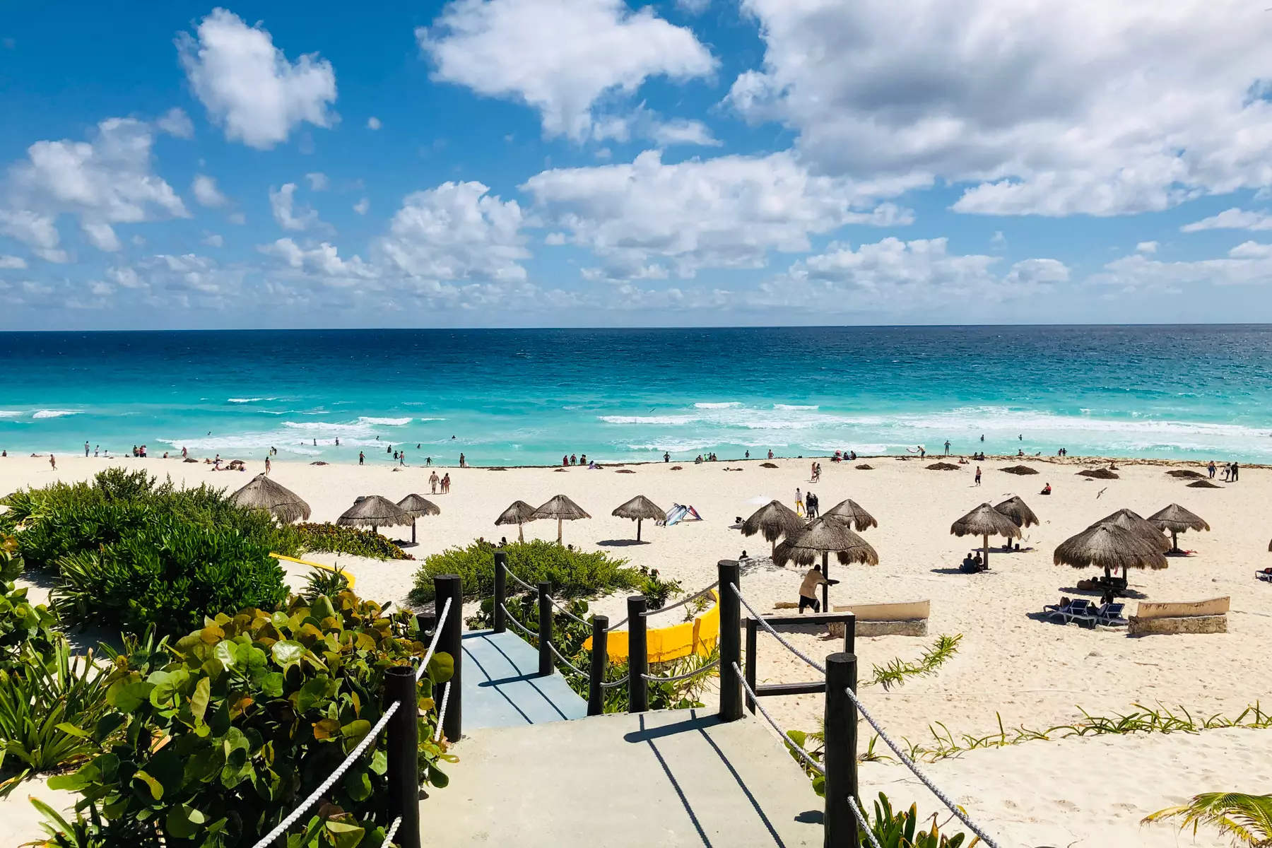 Almennt útsýni frá einum af aðgangunum að strandsvæðinu með Palapa regnhlífum í Cancun, Quintana Roo fylki, Mexíkó, 16. febrúar 2019