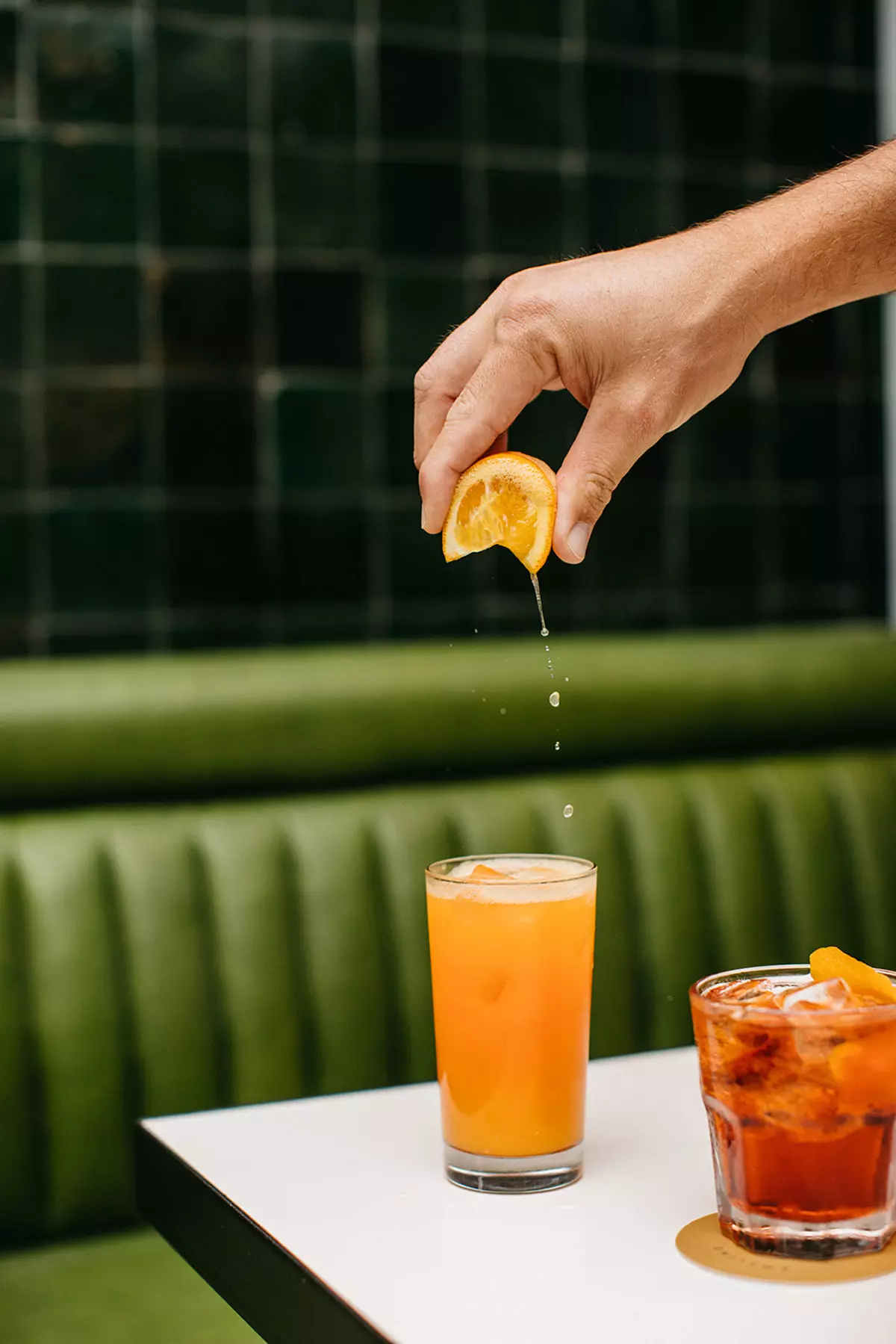 Żewġ cocktails oranġjo bilqiegħda fuq il-mejda