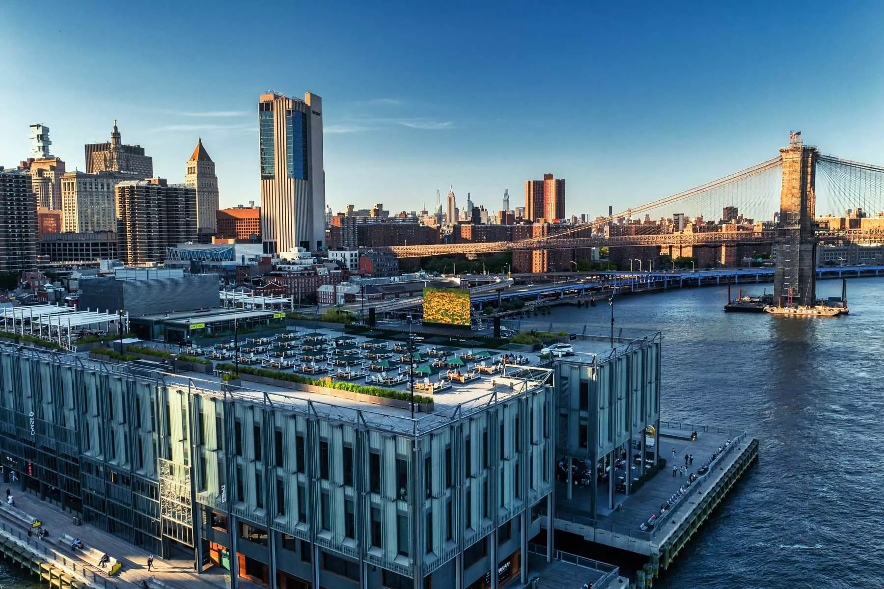 Ukubuka okusemoyeni kwe-The Greens e-Pier 17 e-New York City nokubukwa kwe-East River ne-Brooklyn Bridge