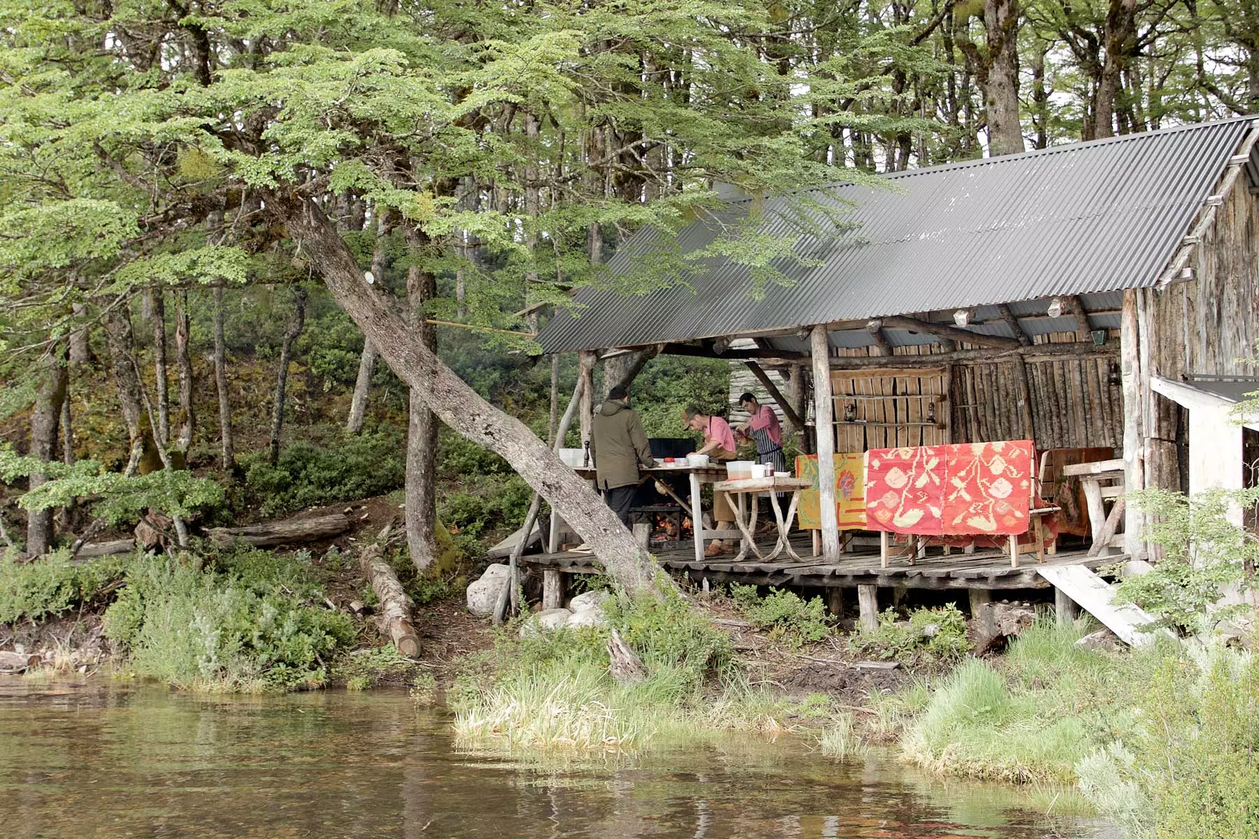 Mga chef nga nag-andam ug pagkaon sa waterside open-air kitchen sa Francis Mallmann property sa Argentina