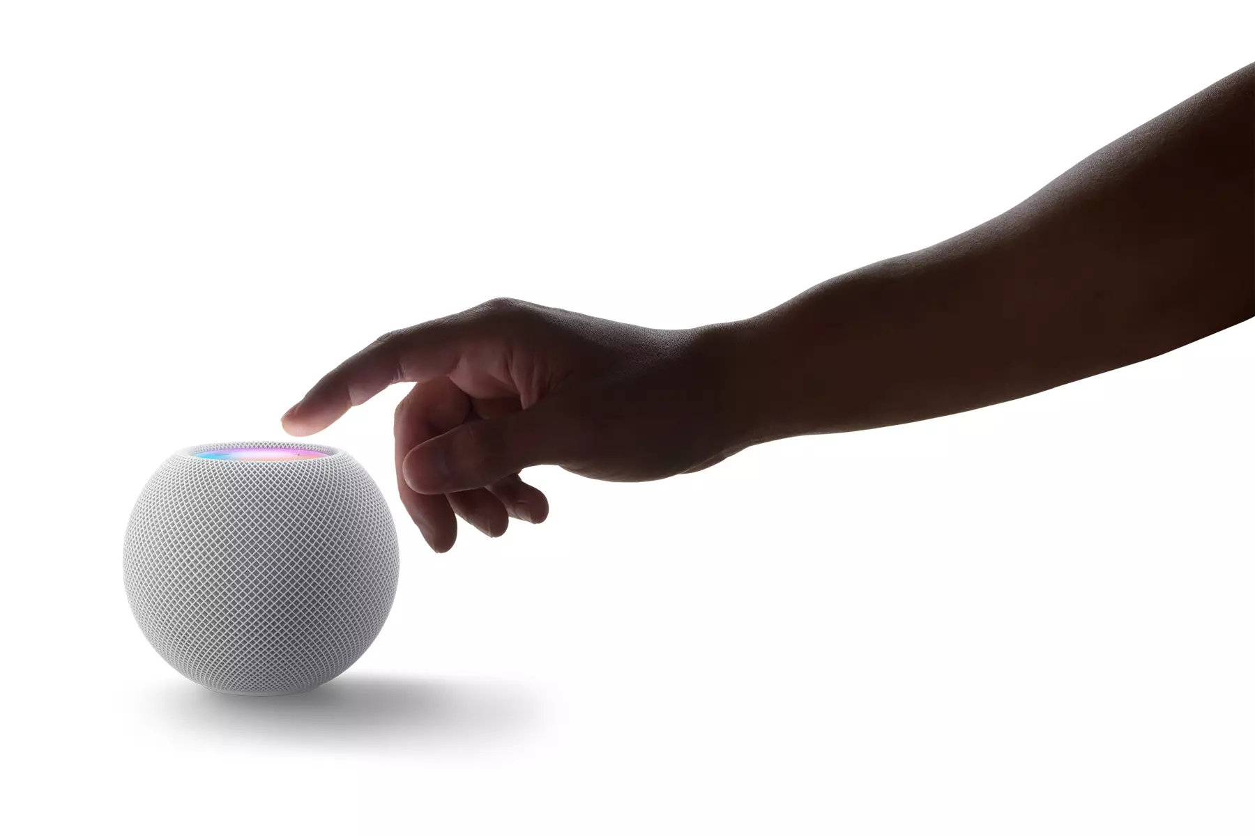 Un braț care se întinde pentru a atinge Apple Home Pod mini