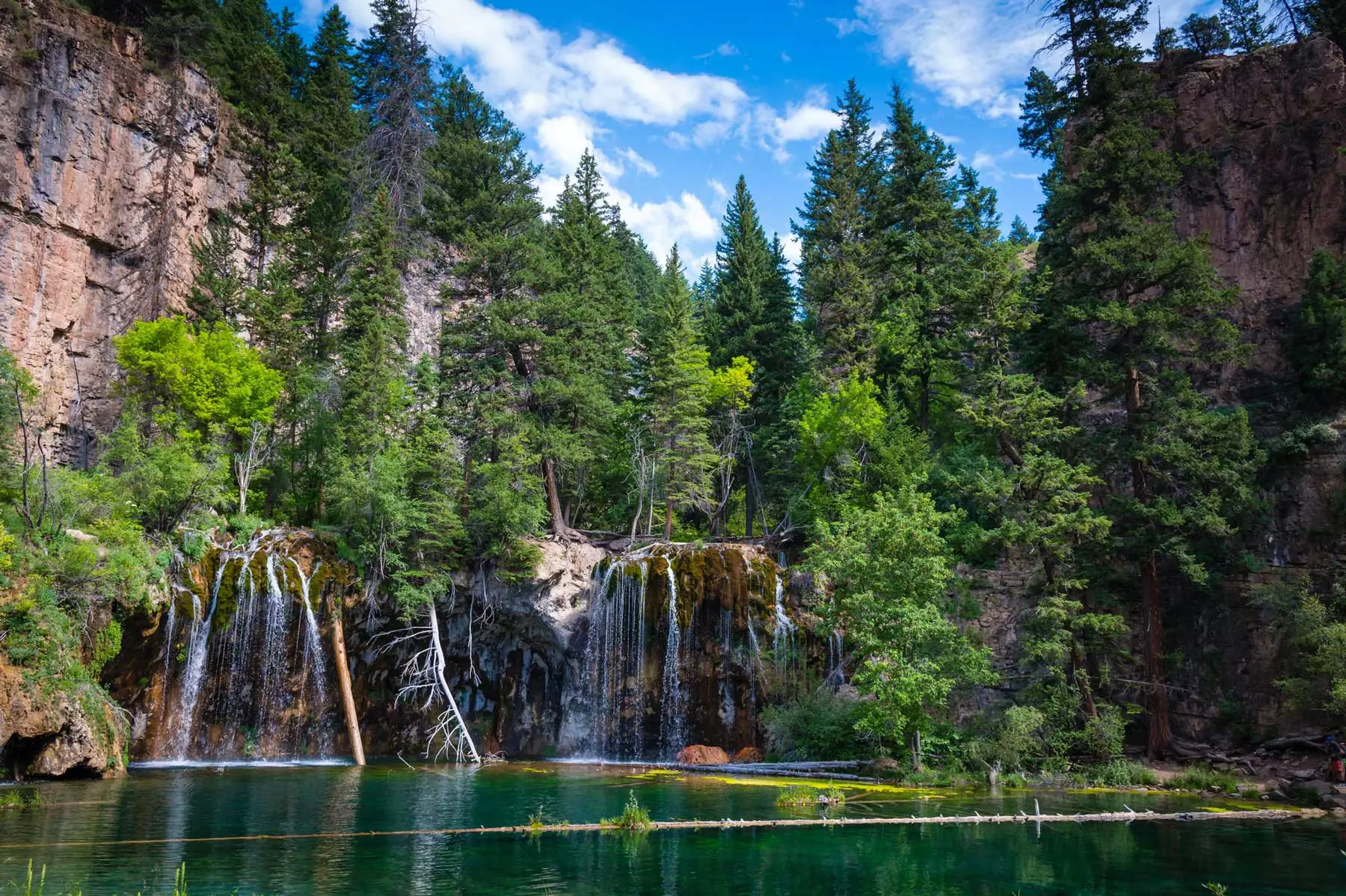 Rippuv järv Colorados, puud ja kosed järve
