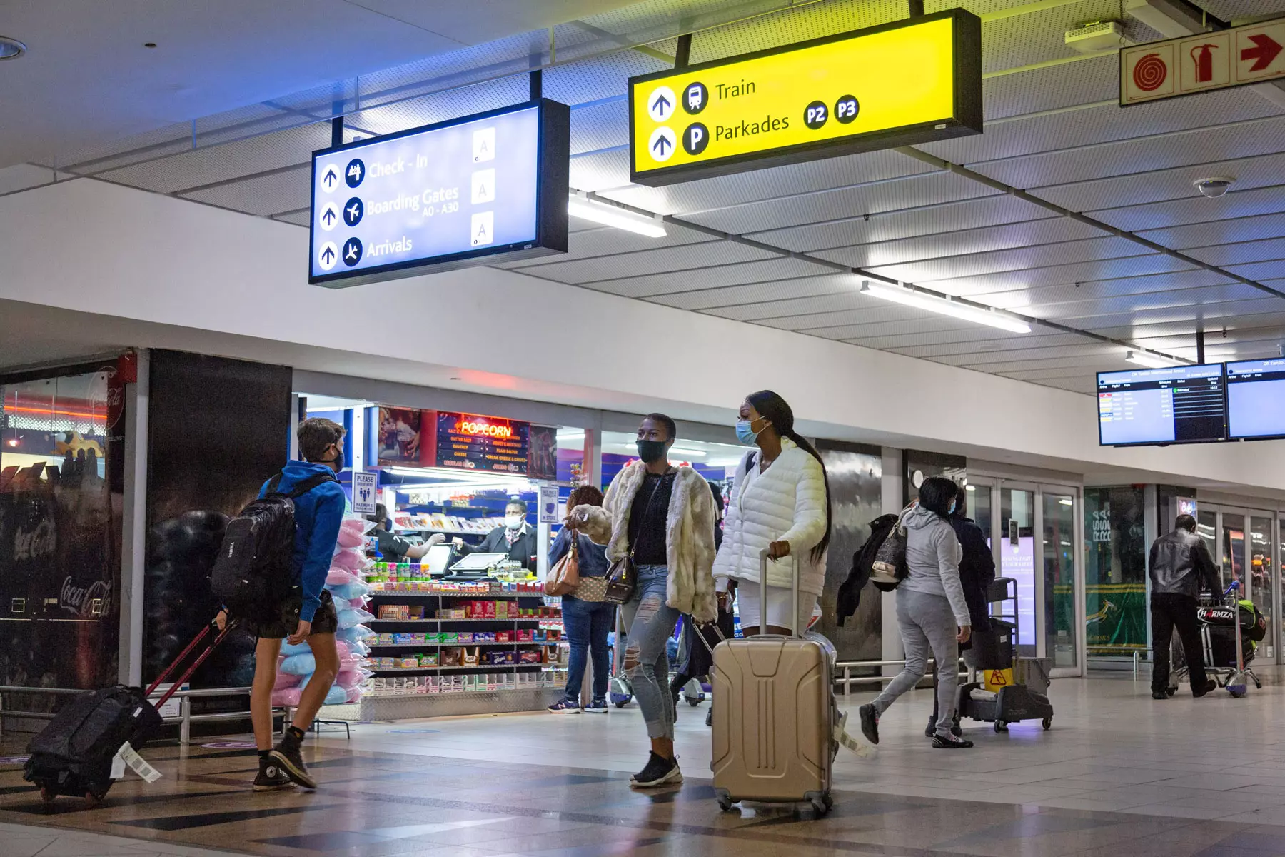 OR टैम्बो अंतरराष्ट्रीय हवाई अड्डे पर यात्रियों को फेस मास्क पहने देखा गया