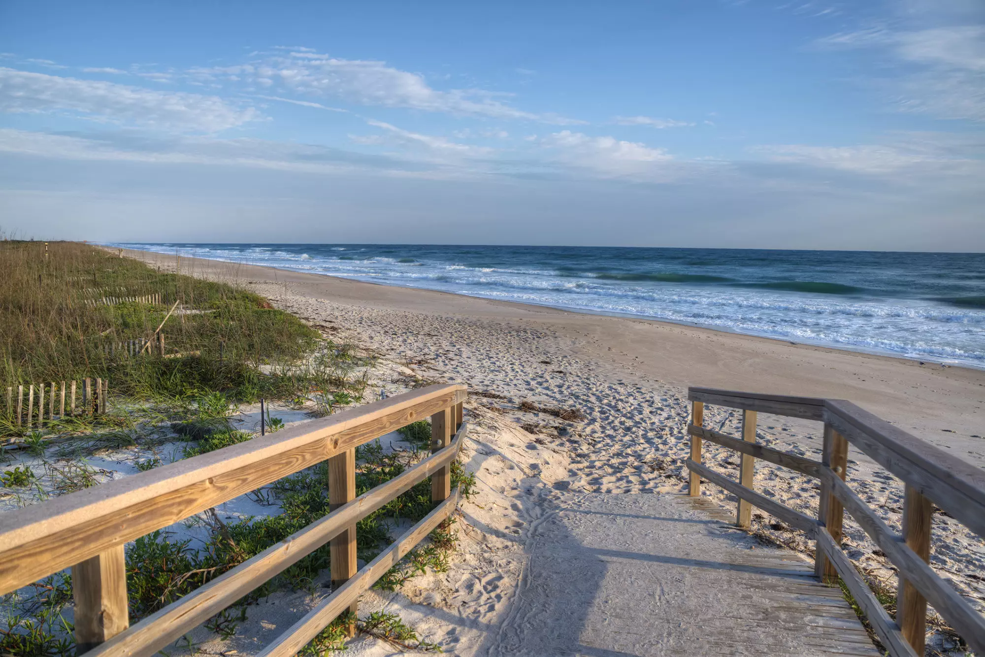 I-boardwalk yokhuni kanye nolwandle olunesihlabathi esimhlophe e-Canaveral National Seashore