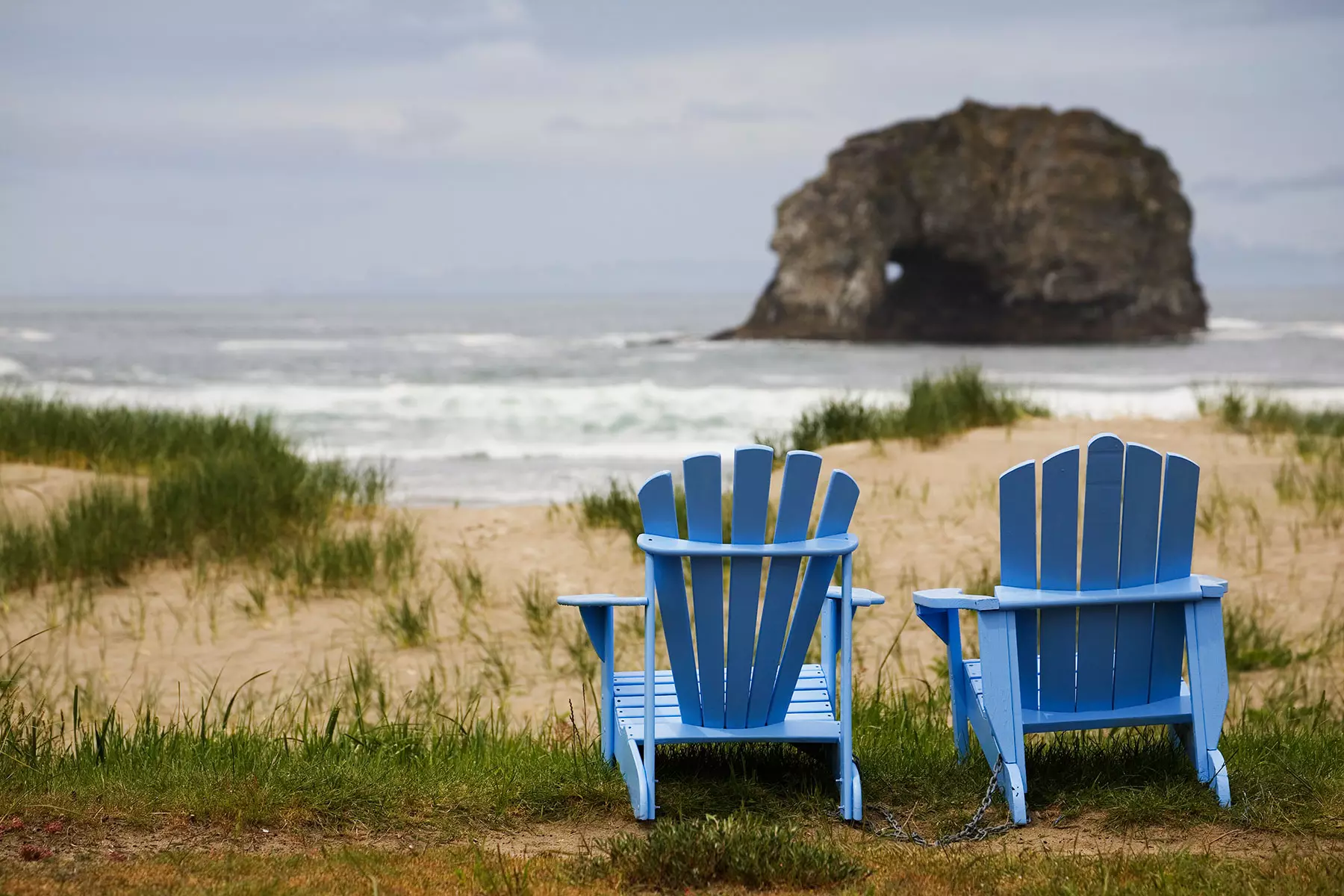 Mipando iwiri ya Blue Adirondack Pagombe la Grassy Rockaway ku Oregon