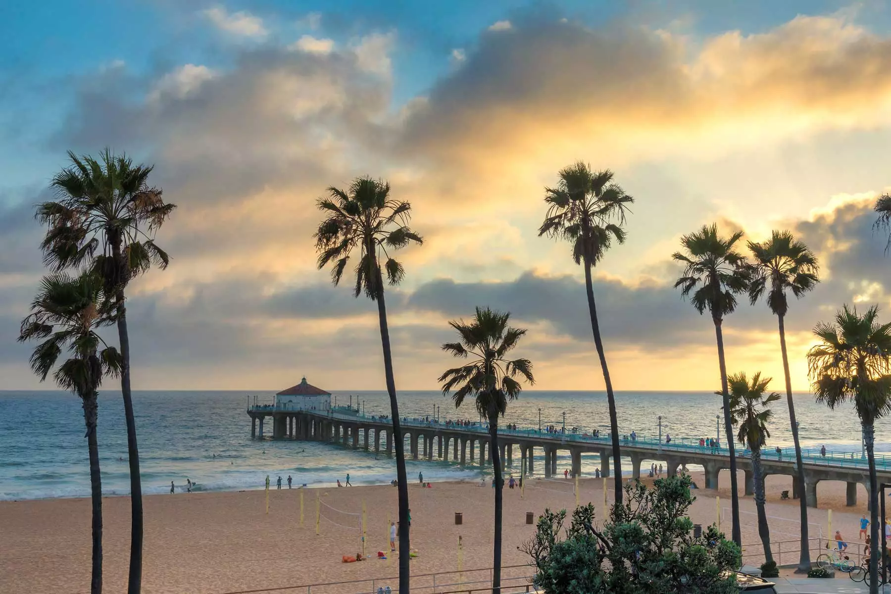 Pálmafák a Manhattan Beachen és a mólón naplementekor, Los Angelesben, Kaliforniában.