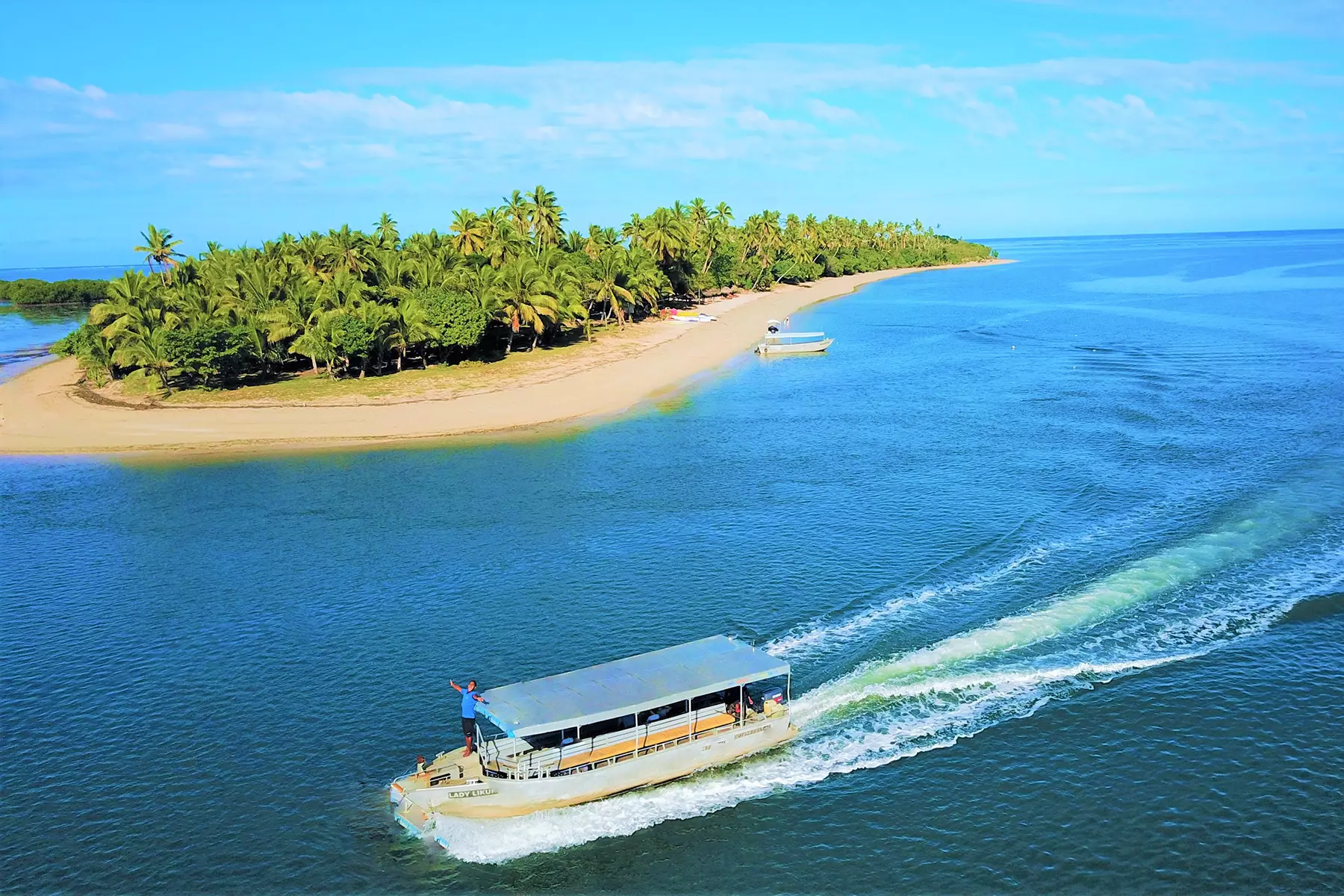 Una barca da trasporto che passa accanto al Likuri Island Resort nelle Fiji