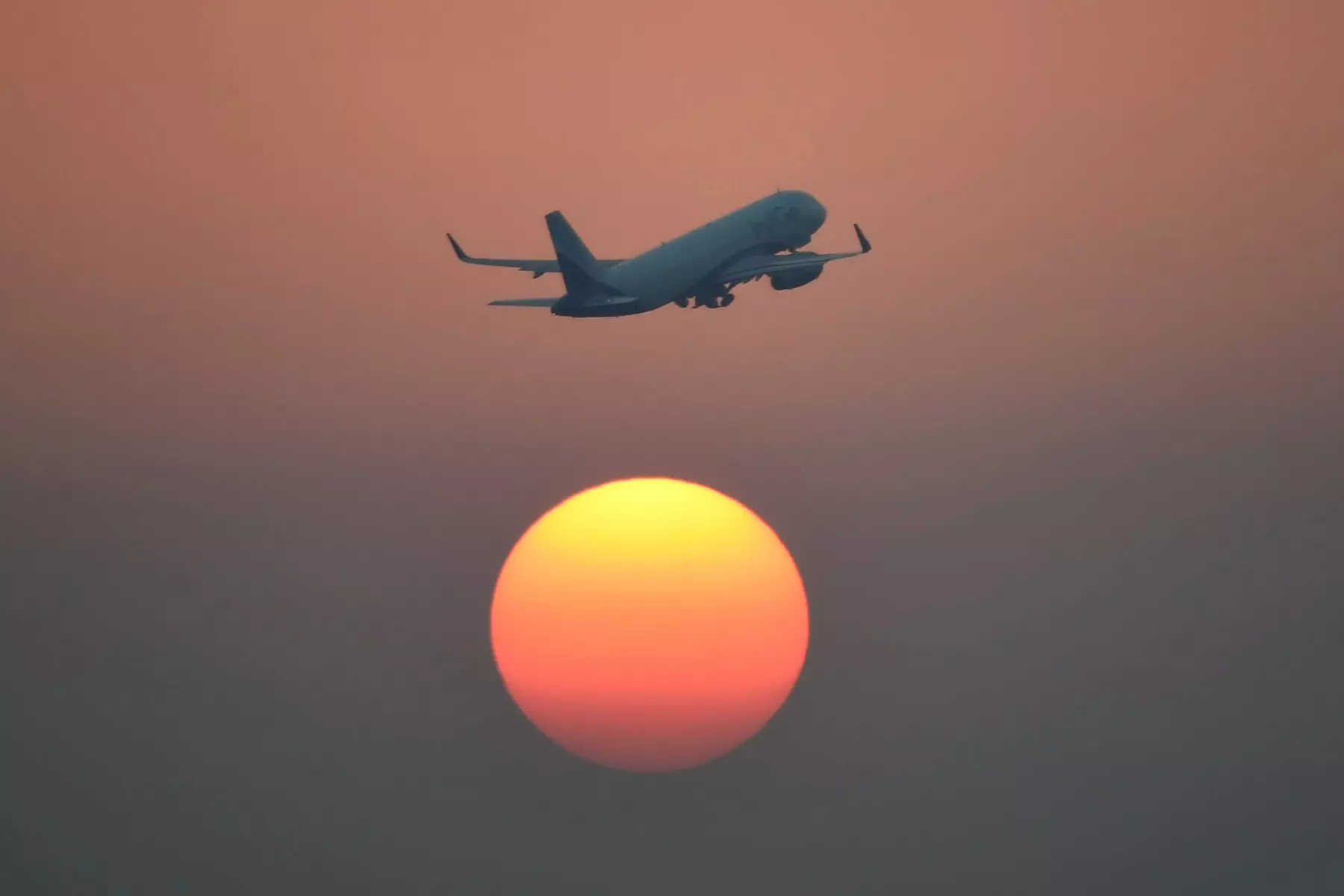 भारत के इंडिगो कैरियर का एक विमान नई दिल्ली में डूबते सूरज के ऊपर उड़ान भरता है