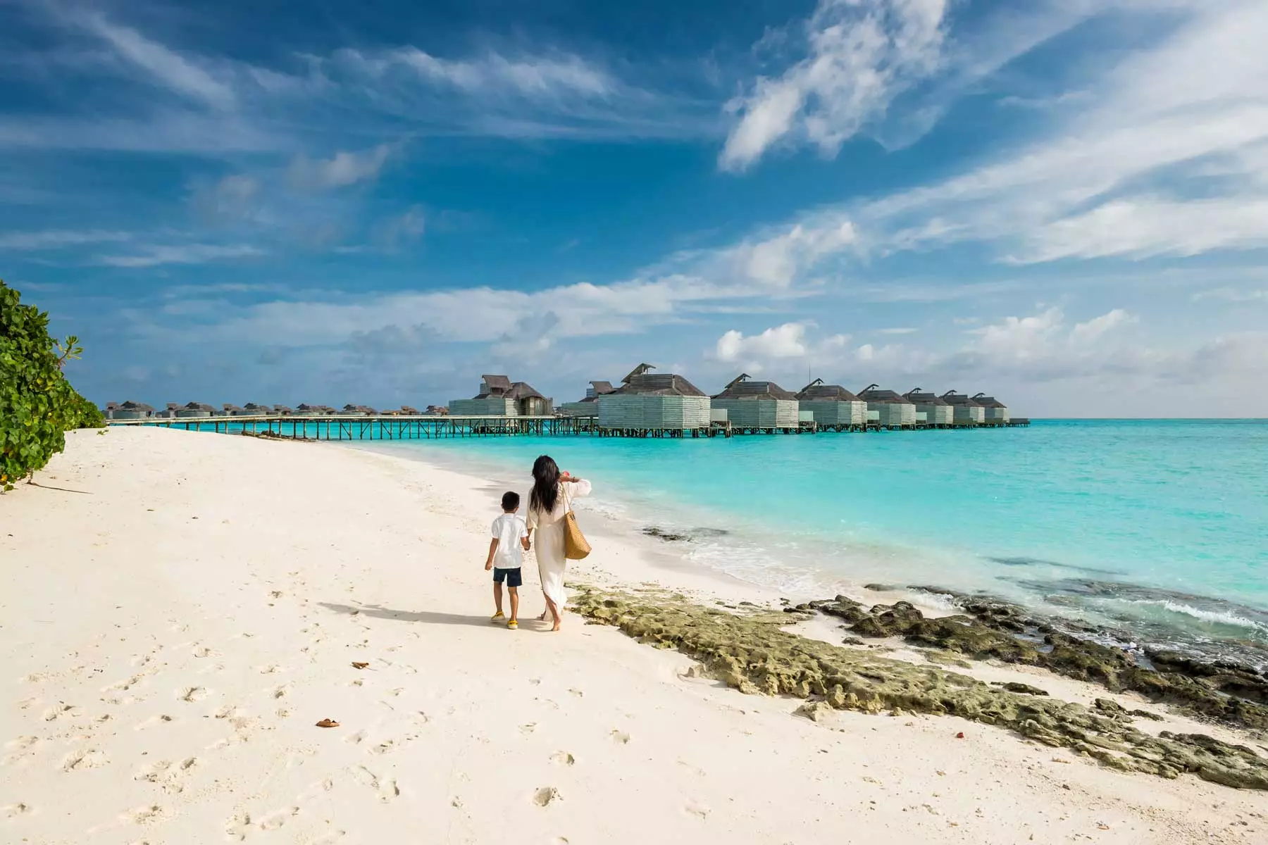 Ibu dan anak lelakinya bermain di pantai di resort pulau Maldives.