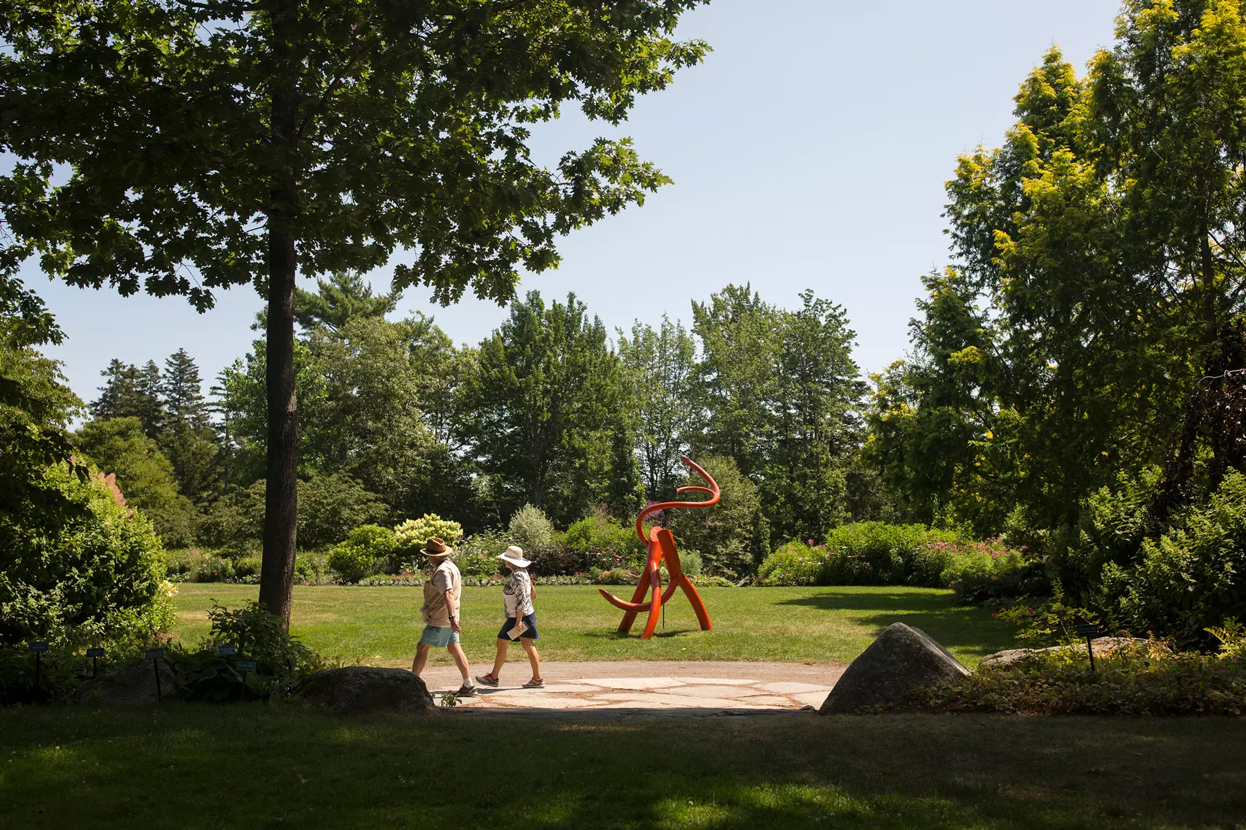 Návštevníci v pobrežnej Maine Botanical Gardens sa v piatok 2. augusta 2019 prechádzajú popri soche umelca Steva Tobina