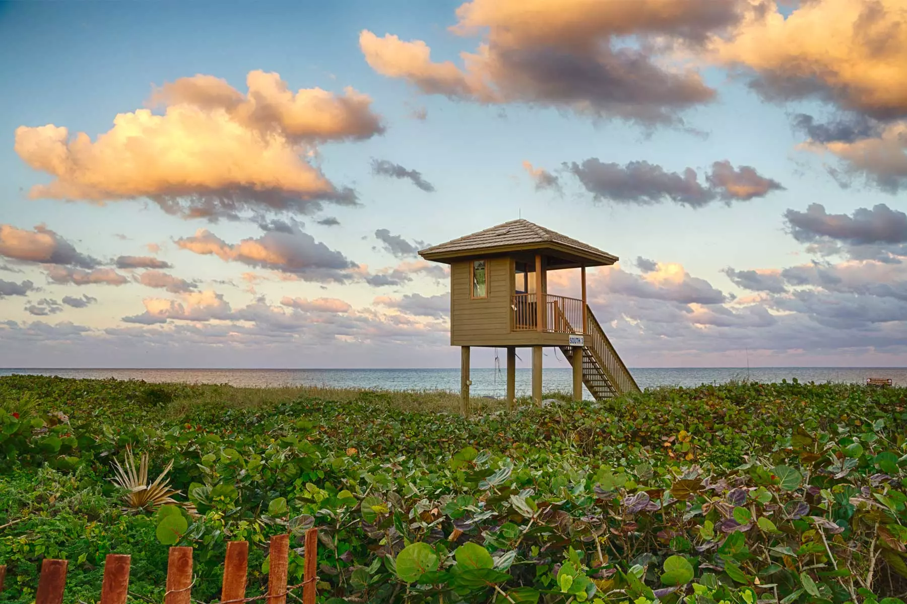 Delray Beach ved solnedgang med skyer og havdruer.