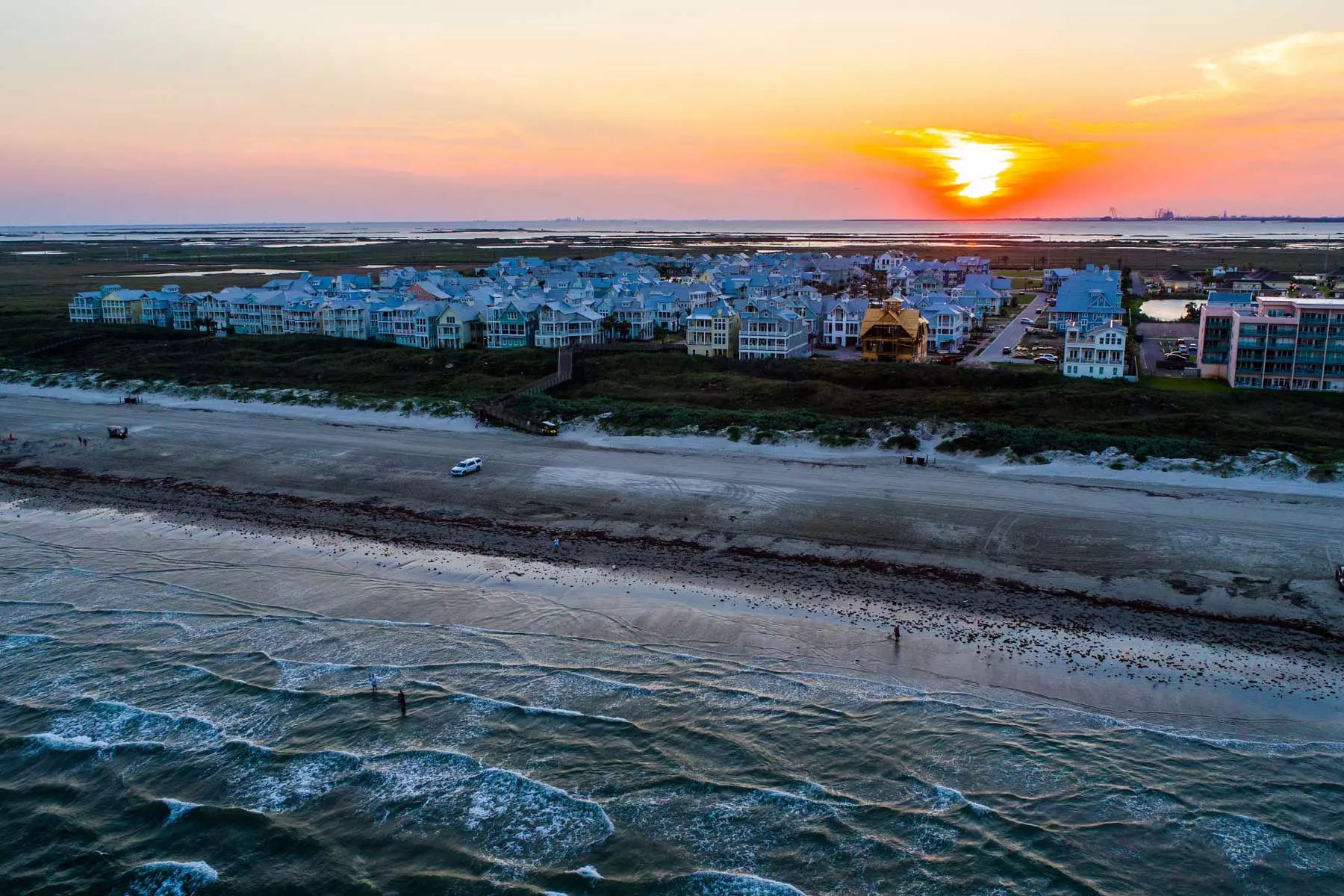 Port Aransas Texas အနီးရှိ Padre ကျွန်းအမျိုးသား Shoreline သဲသောင်ပြင်တွင် ပျက်စီးနေသောလှိုင်းများထက် နေထွက်သည်။