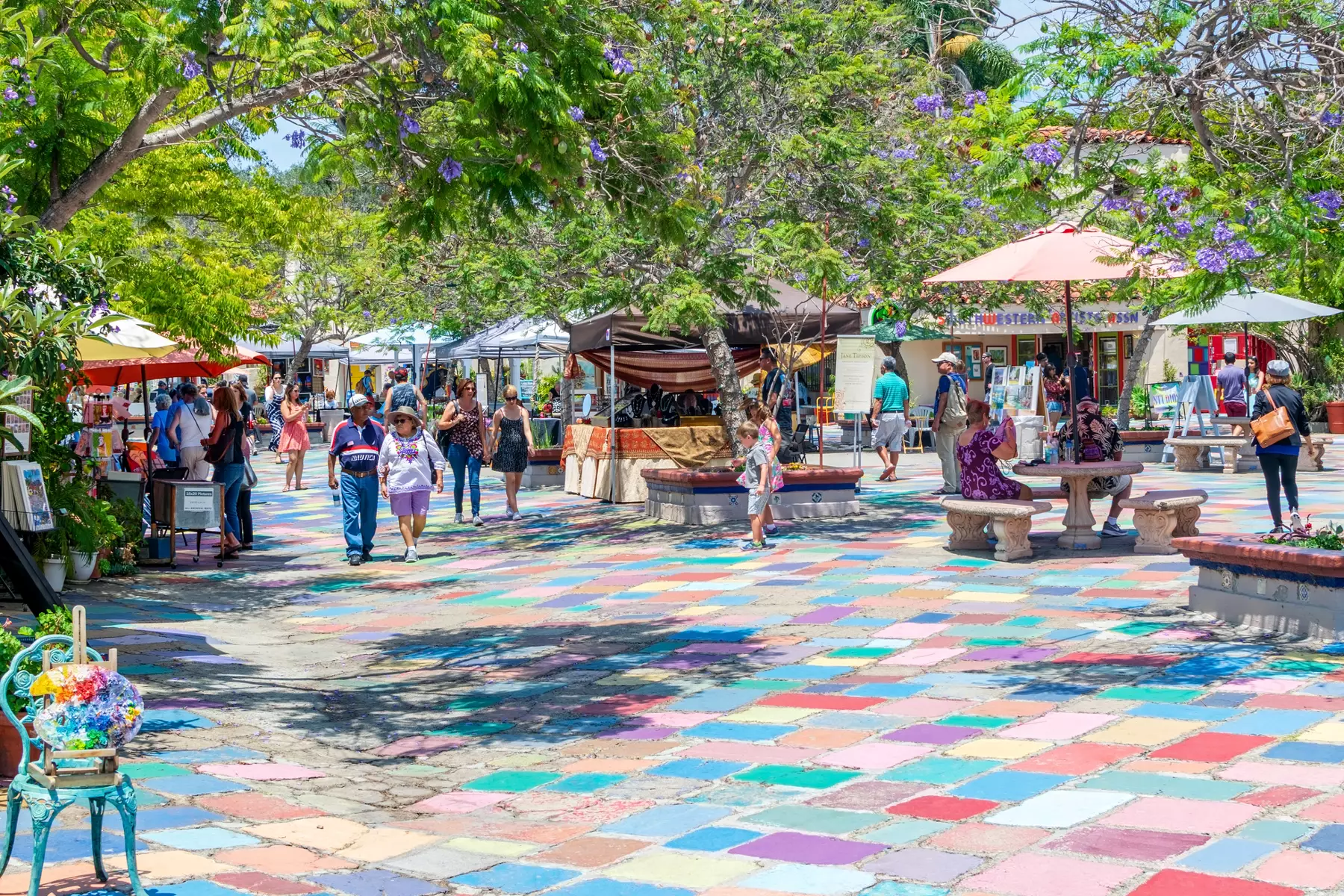 Parcul Balboa din San Diego, CA, cu muzee, poteci, zone cu iarbă, grădini botanice, comercianți, artiști stradali și vânzători în aer liber.