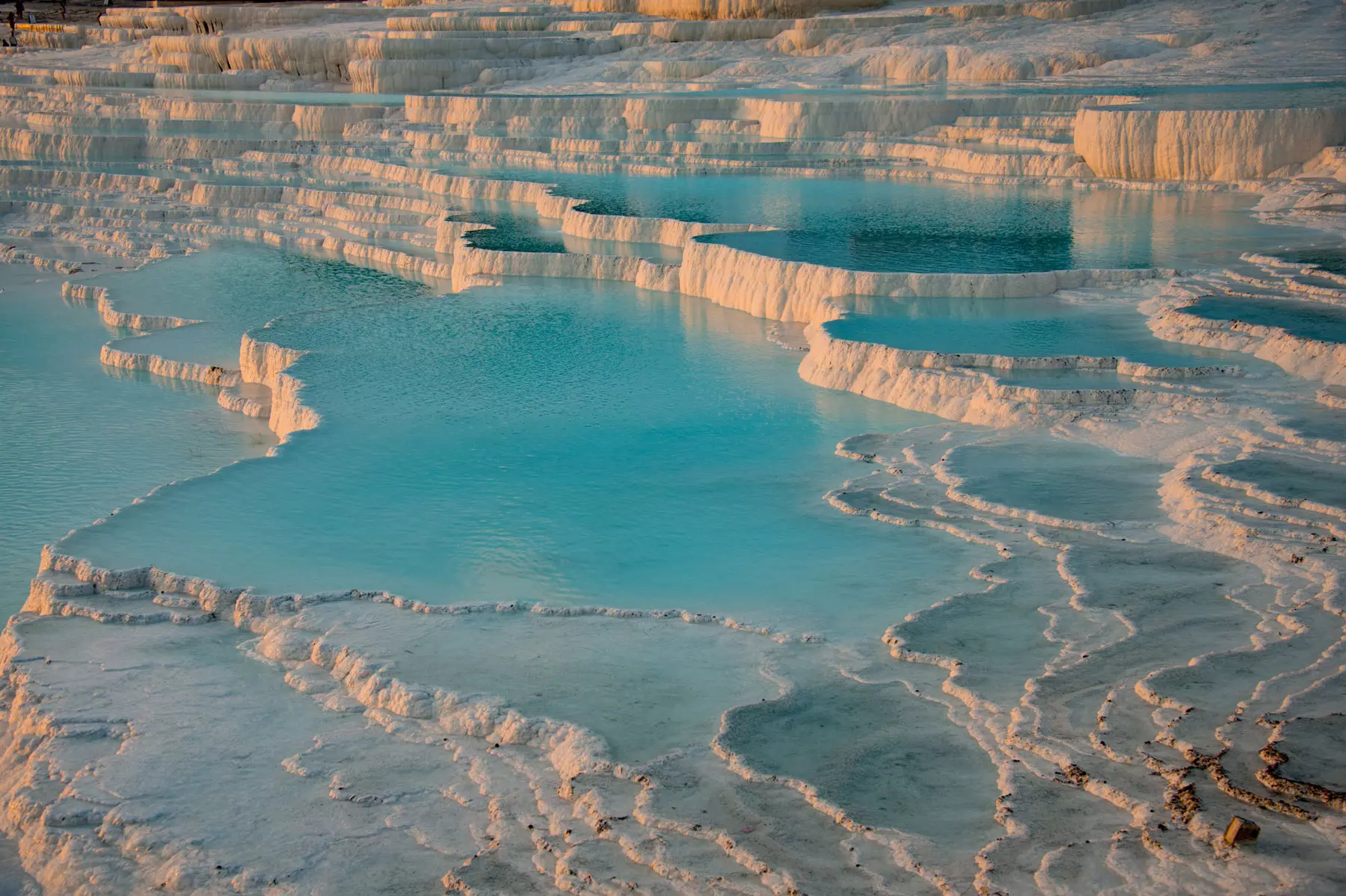 สระน้ำสีฟ้าครามบนขั้นบันไดของ Pamukkale ประเทศตุรกี