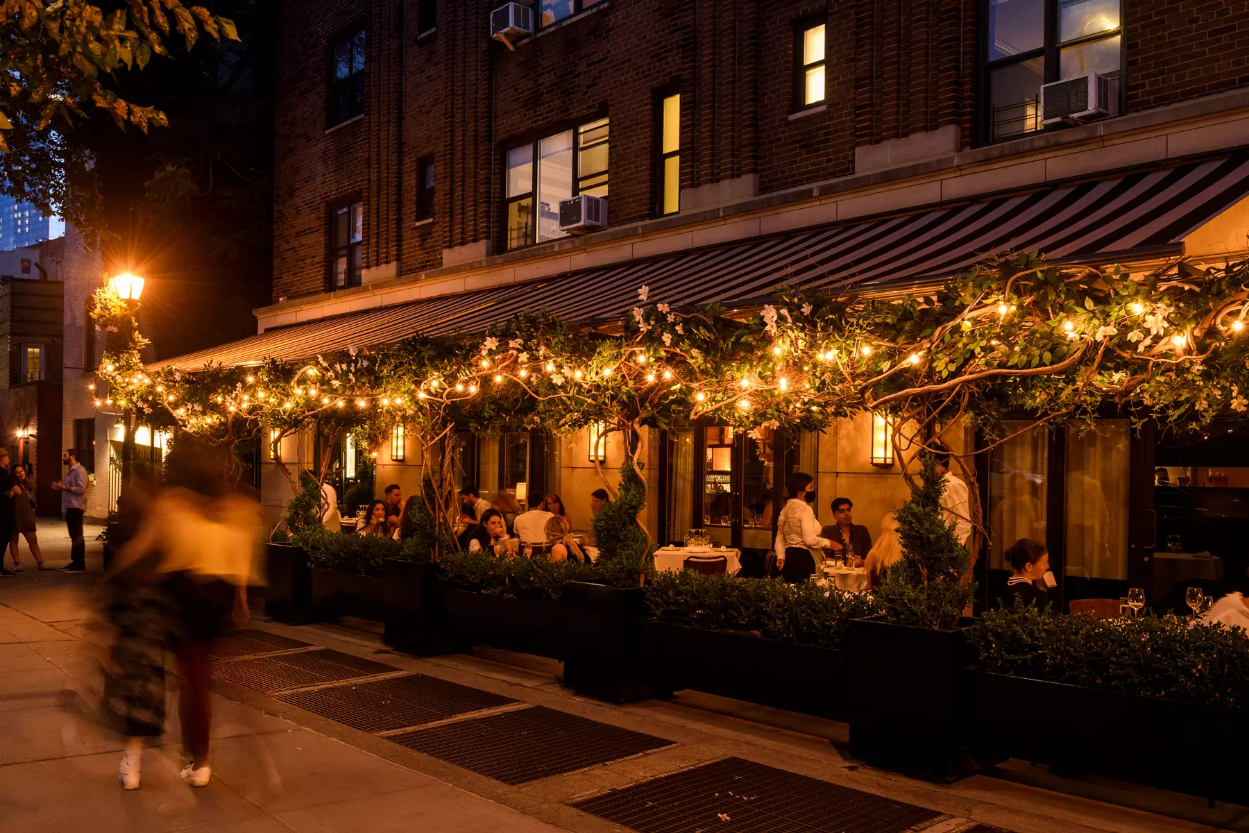 Aftenudsigt over finurlig terrasse oplyst af eventyrlys ved Hancock St