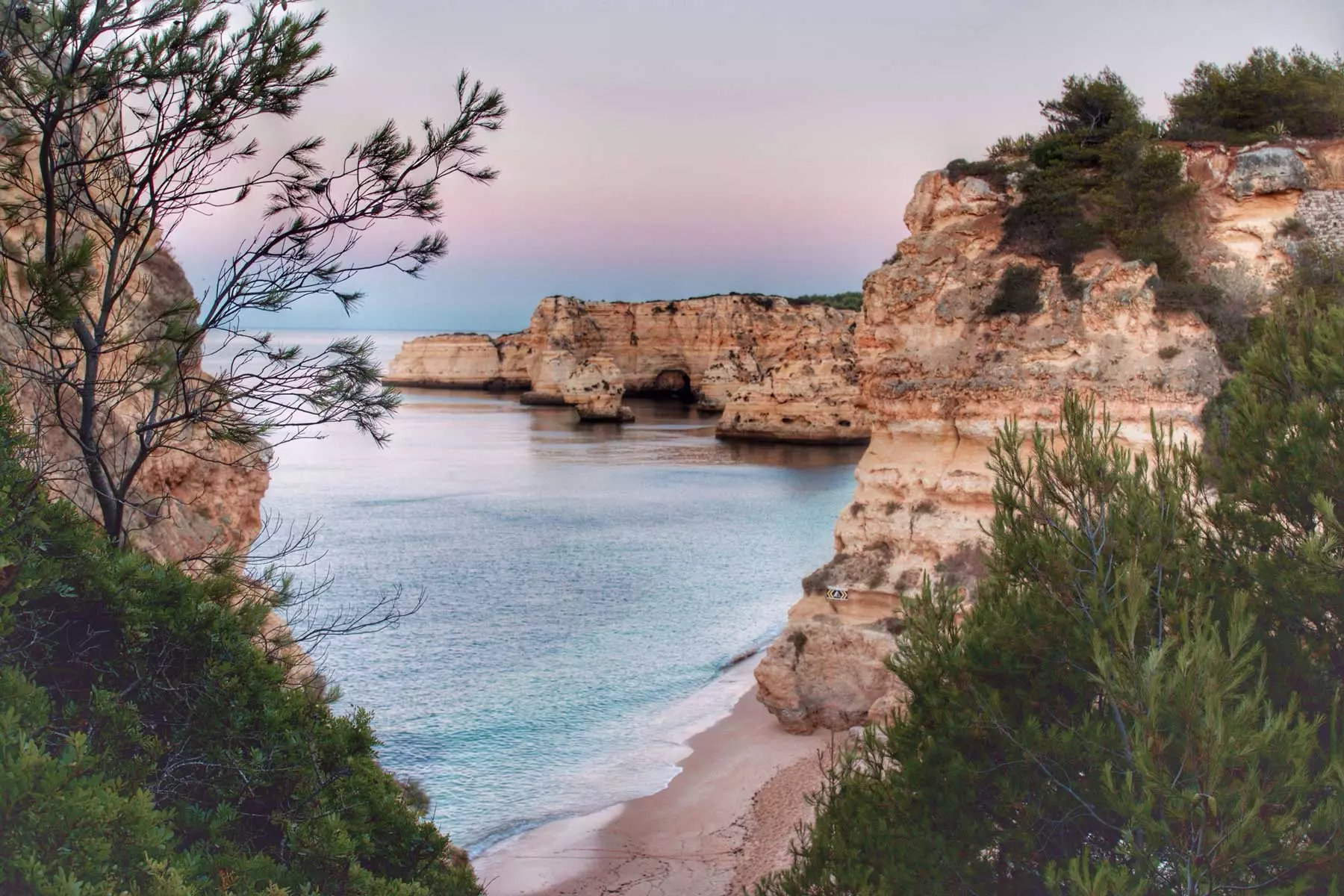 Formaciones rocosas en el mar en Praia da Marinha durante la puesta de sol