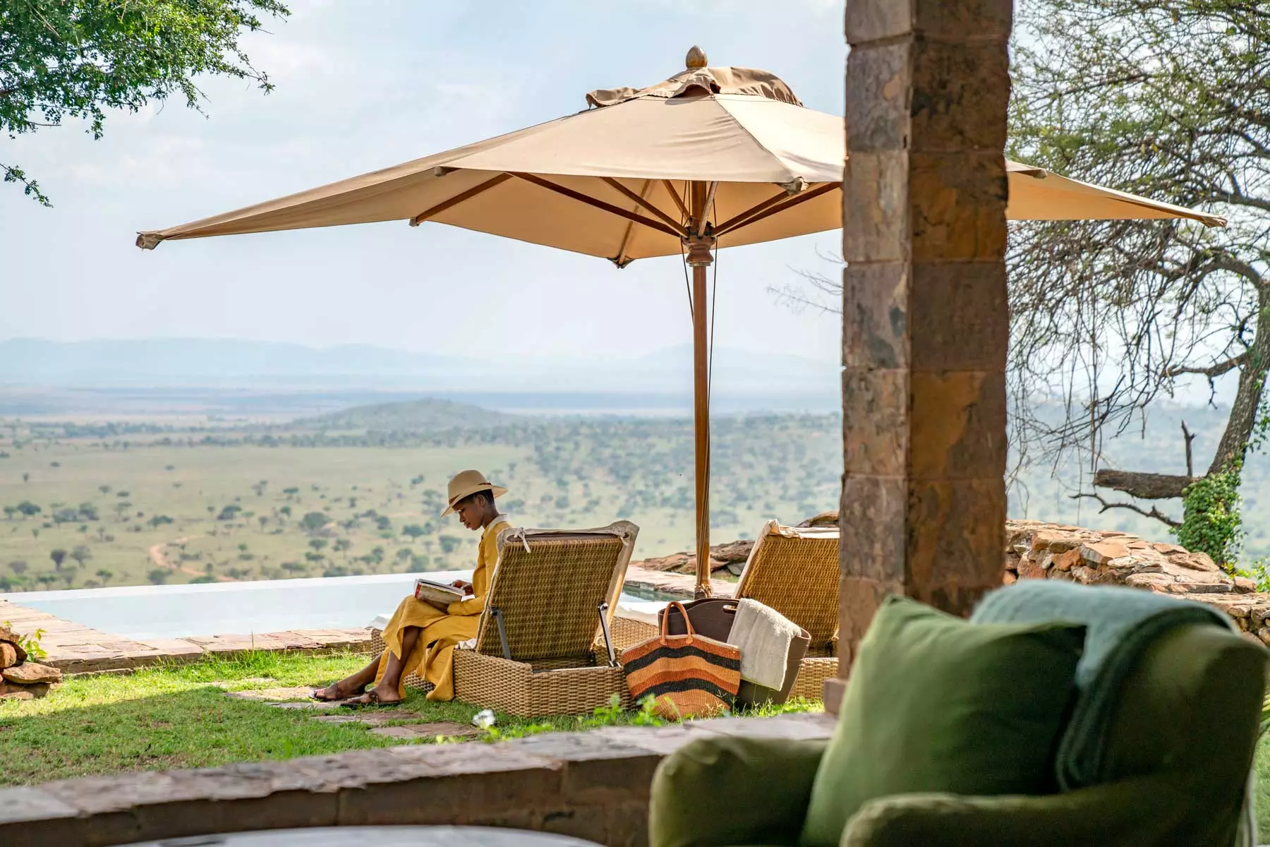 Eng Fra liest op der Terrass bei Singita Grumeti, als ee vun de beschten Hoteler op der Welt gewielt