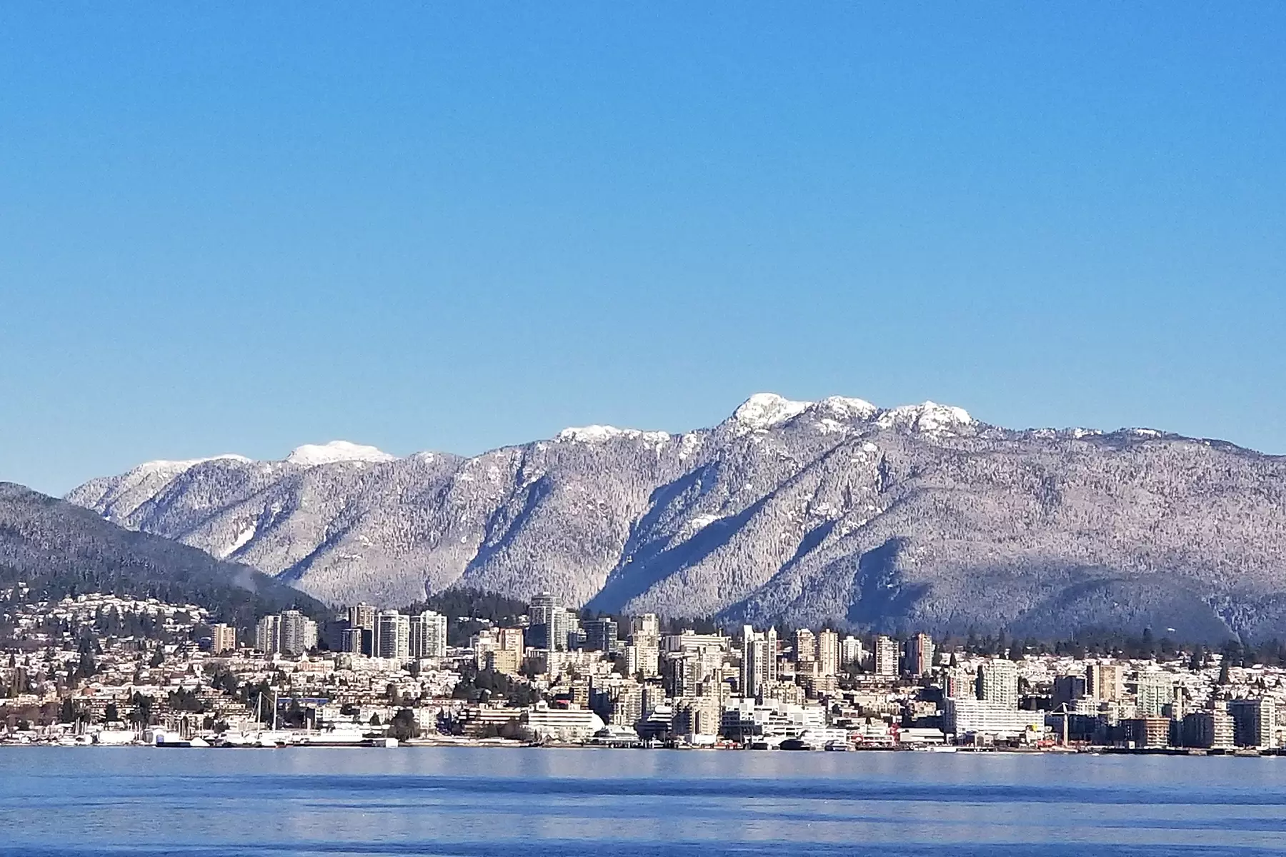 Malebný výhľad na more a zasnežené hory v severnom Vancouveri, Kanada