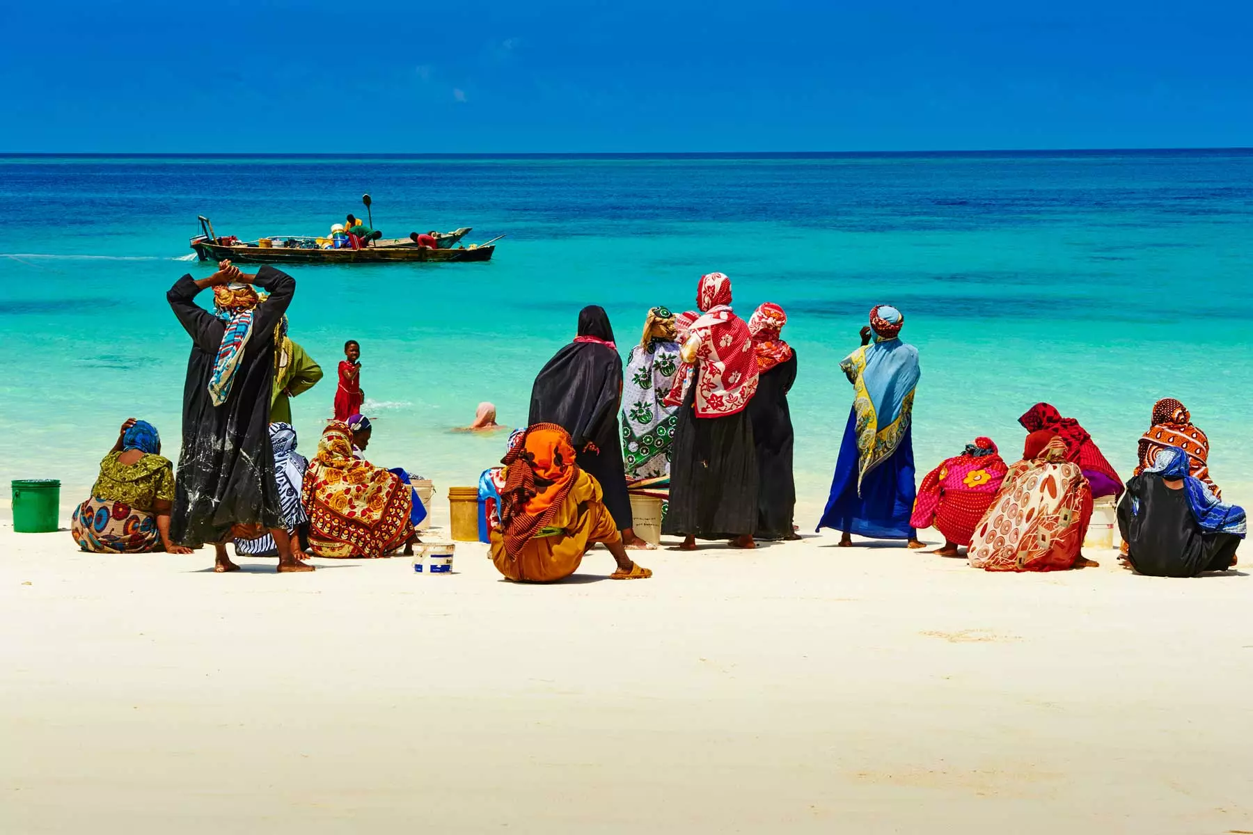 تنزانیہ کے زنزیبار جزیرے کے Unguja میں Nungwi کے ساحل پر خواتین ماہی گیری کی کشتی کے ساتھ قطار میں کھڑی ہیں۔ تنزانیہ