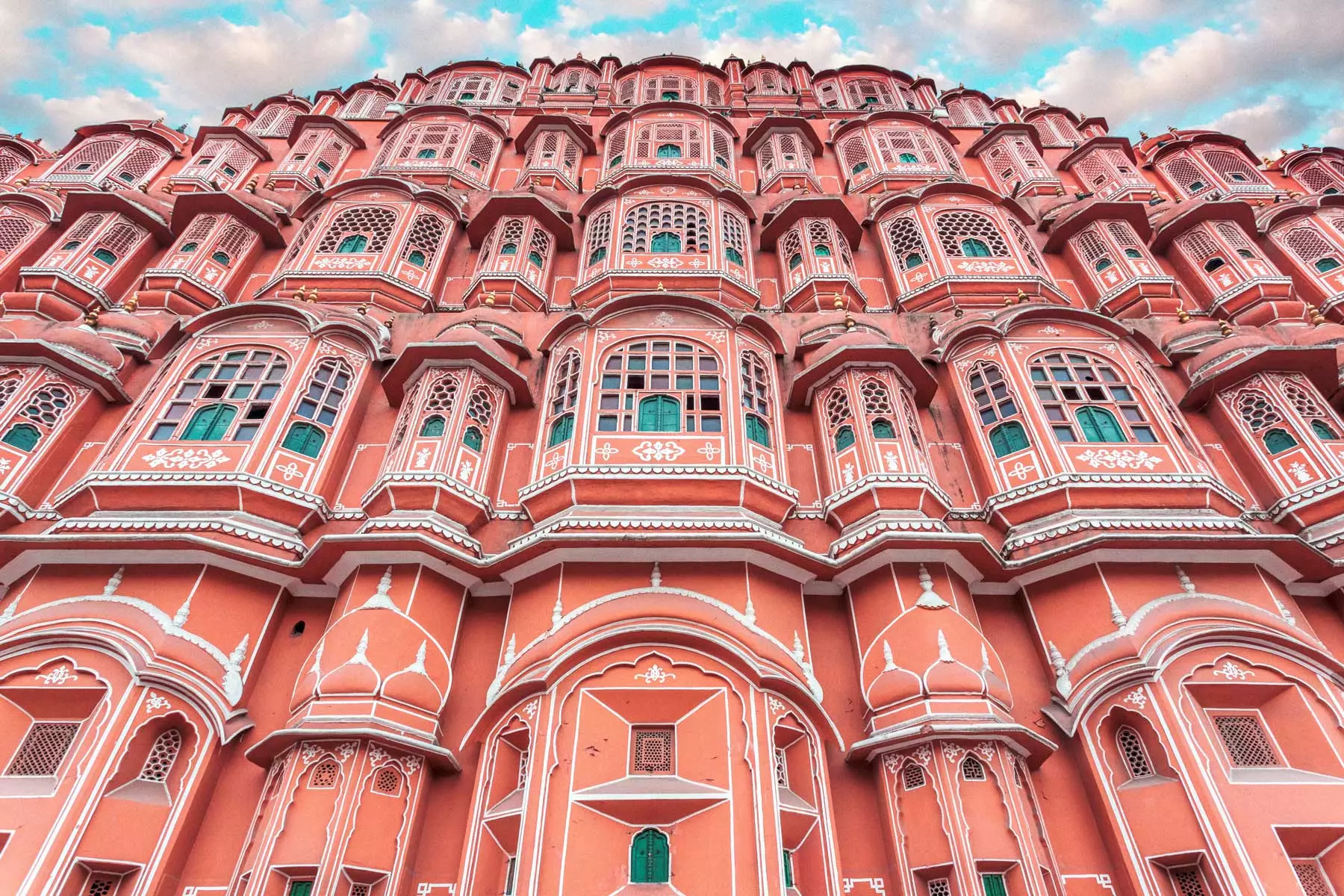 Mionsonraí bándearg agus bán de Pálás na gaotha i Jaipur, India, vótáil ar cheann de na cathracha is fearr ar domhan