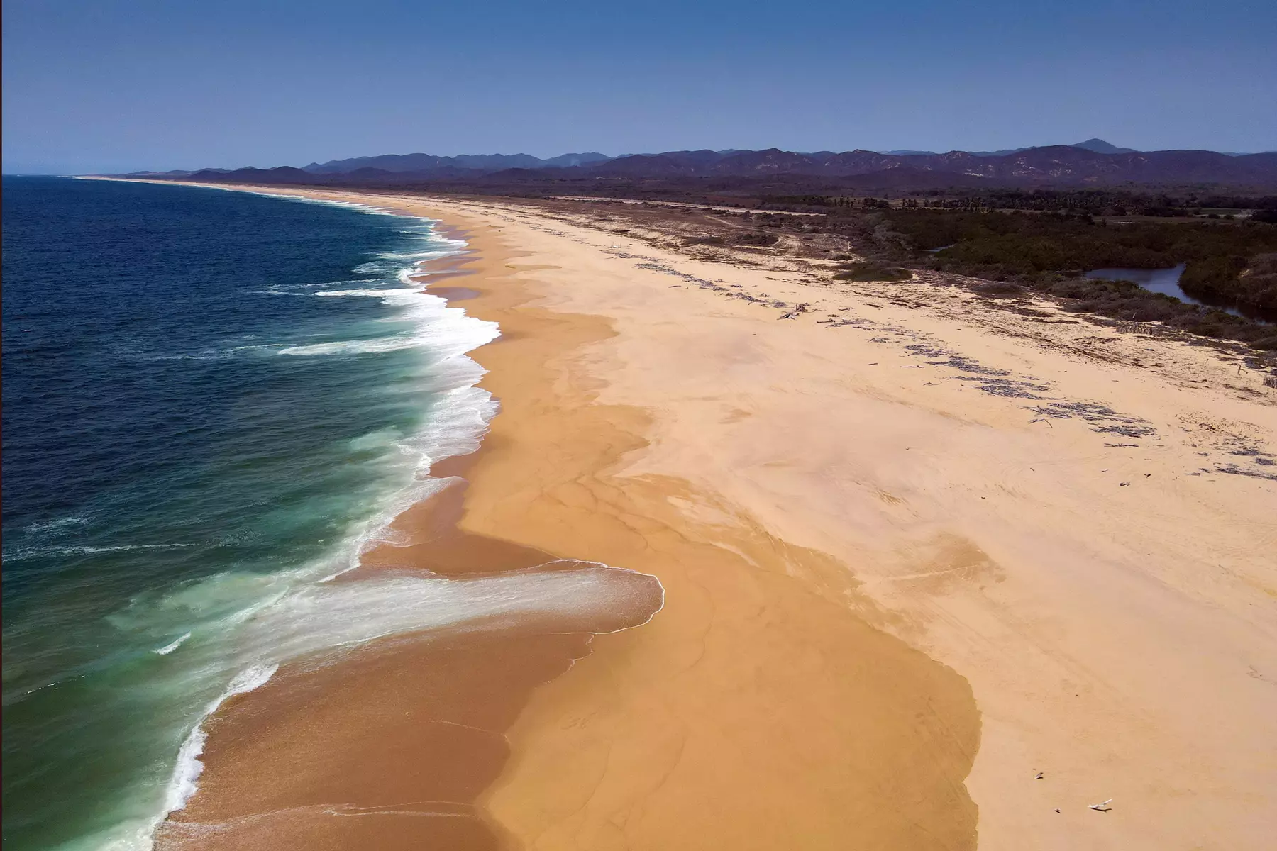 Batanta surfo sur Mayto Beach, Cabo Corrientes, Jalisco-ŝtato, Meksiko. Mayto Beach estas longa kutime dezerta peco de marbordo kiu havas sovaĝan marbordan paŭzon kiu malinstigas naĝantojn.