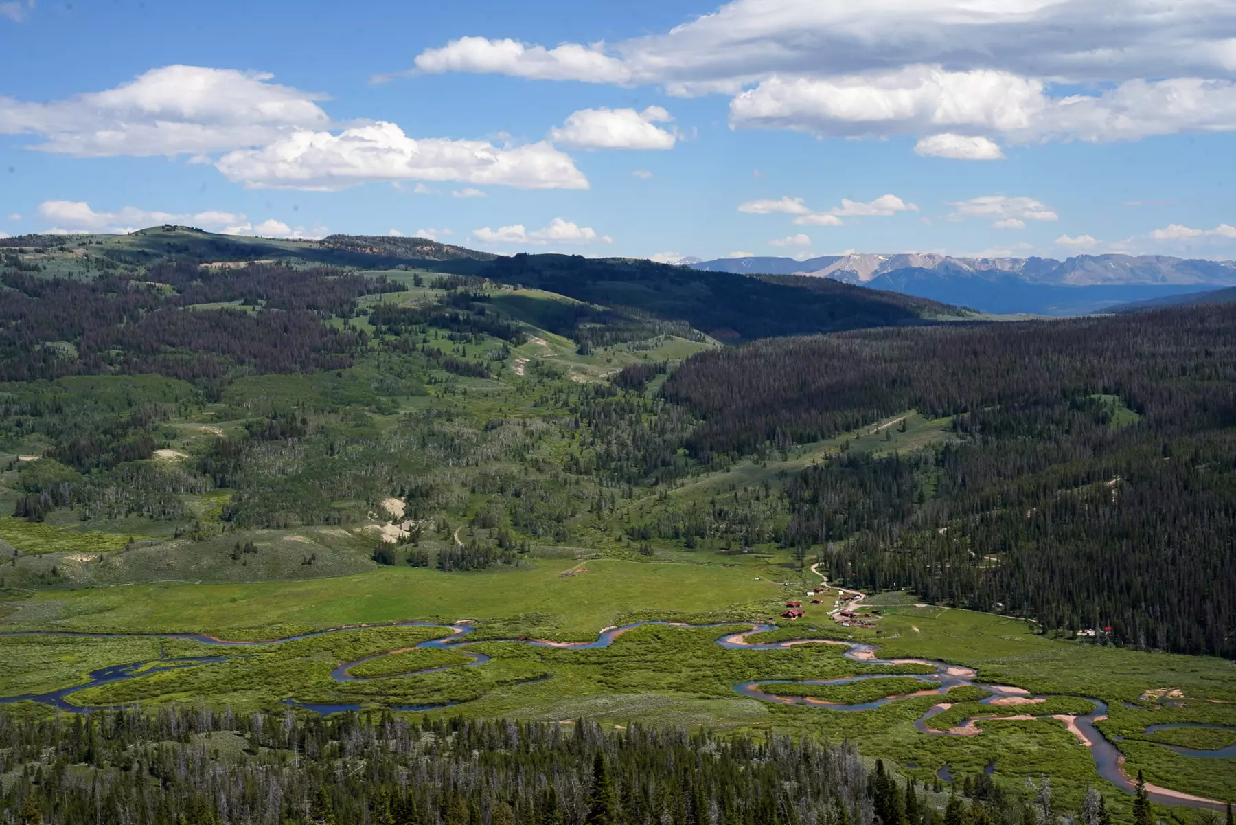 Pogled iz zraka na krivudavu rijeku i ranč Darwin među planinama Wyominga