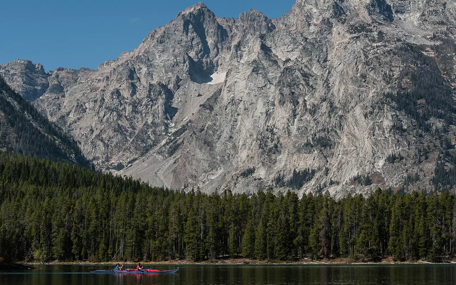 [NEPREVERJENA VSEBINA] dva kajakaša, ki plavata pod zahodnim grebenom gore Moran. na jezeru Leigh v narodnem parku Grand Teton v Wyomingu.