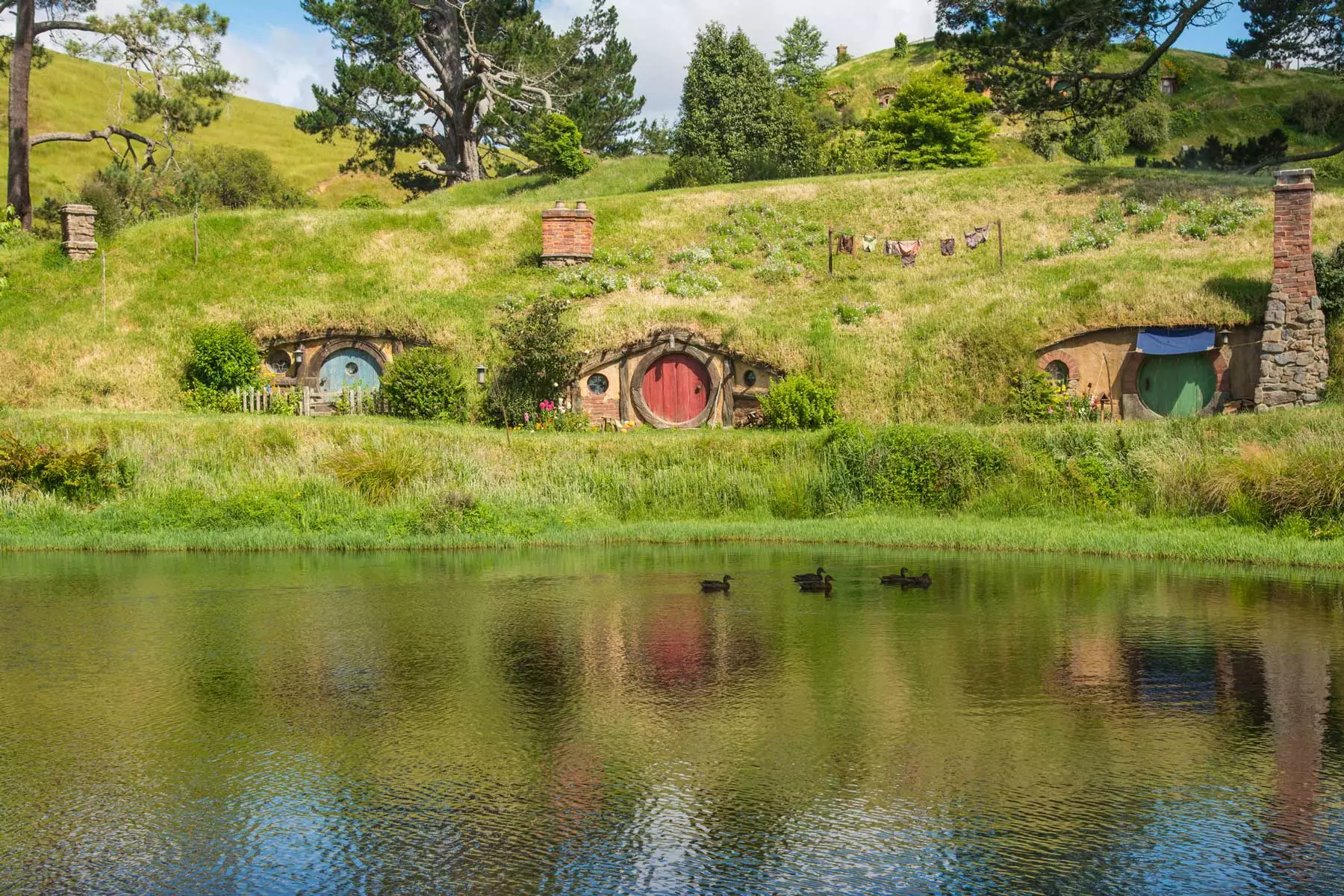 Vista panoramica dei buchi Hobbit sul lungomare nel set cinematografico di Hobbiton a Matamata, Nuova Zelanda.