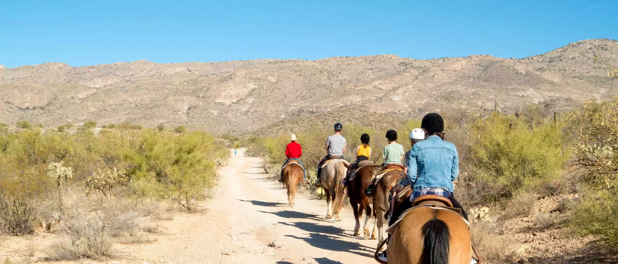 Familja fuq Trail Ride fid-deżert ta' Arizona