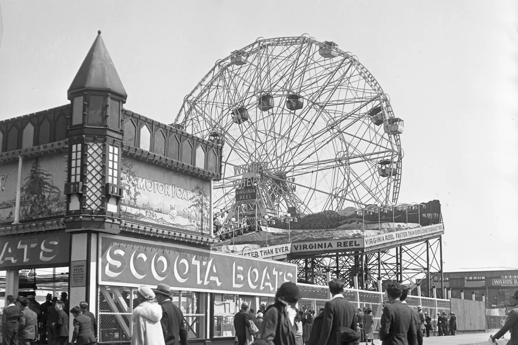 Fa'amaumauga o ata o tagata o lo'o savavali i le motu o Coney i luma o Wonder Wheel