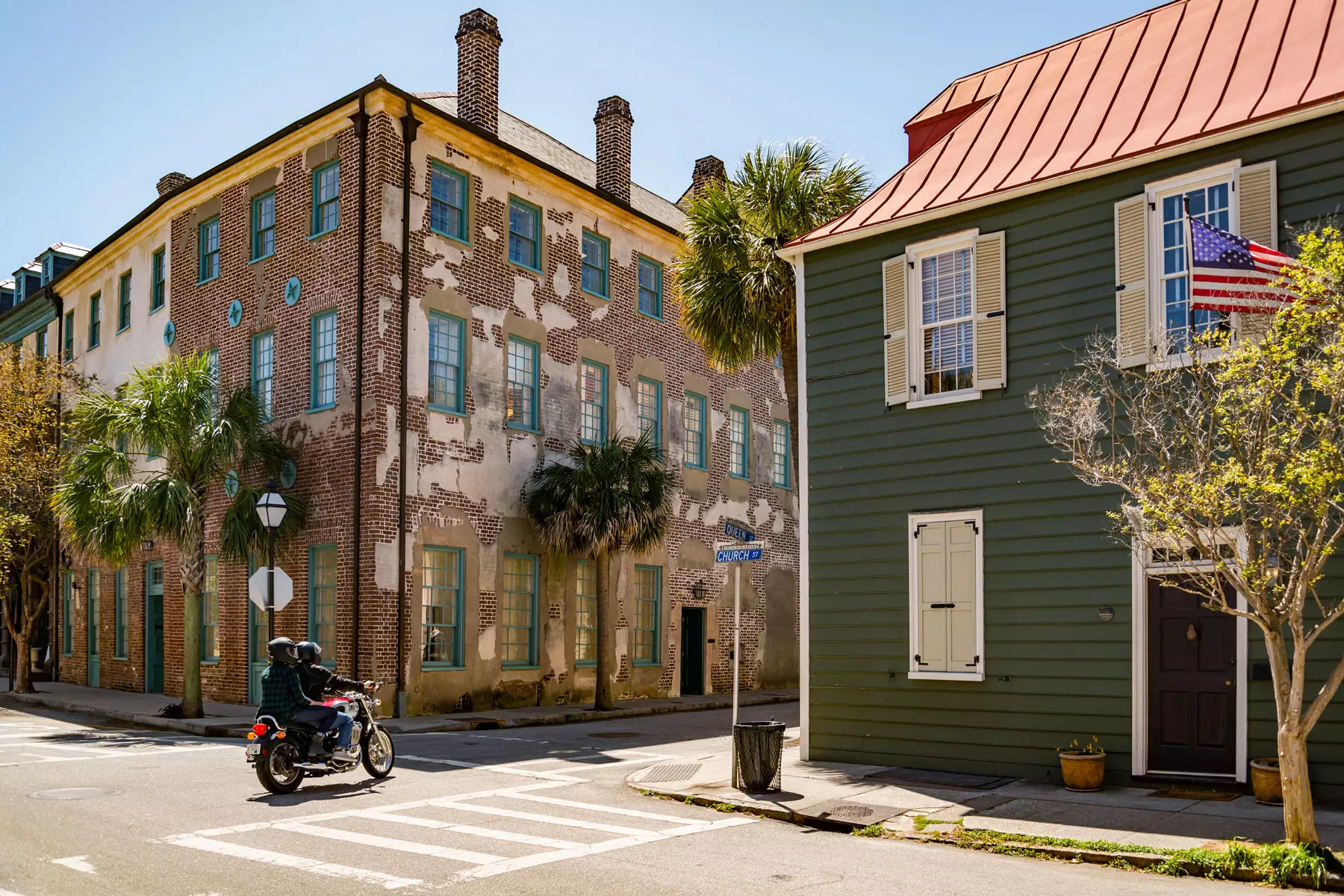 Două persoane merg cu motocicleta în centrul istoric al orașului Charleston, Carolina de Sud, SUA