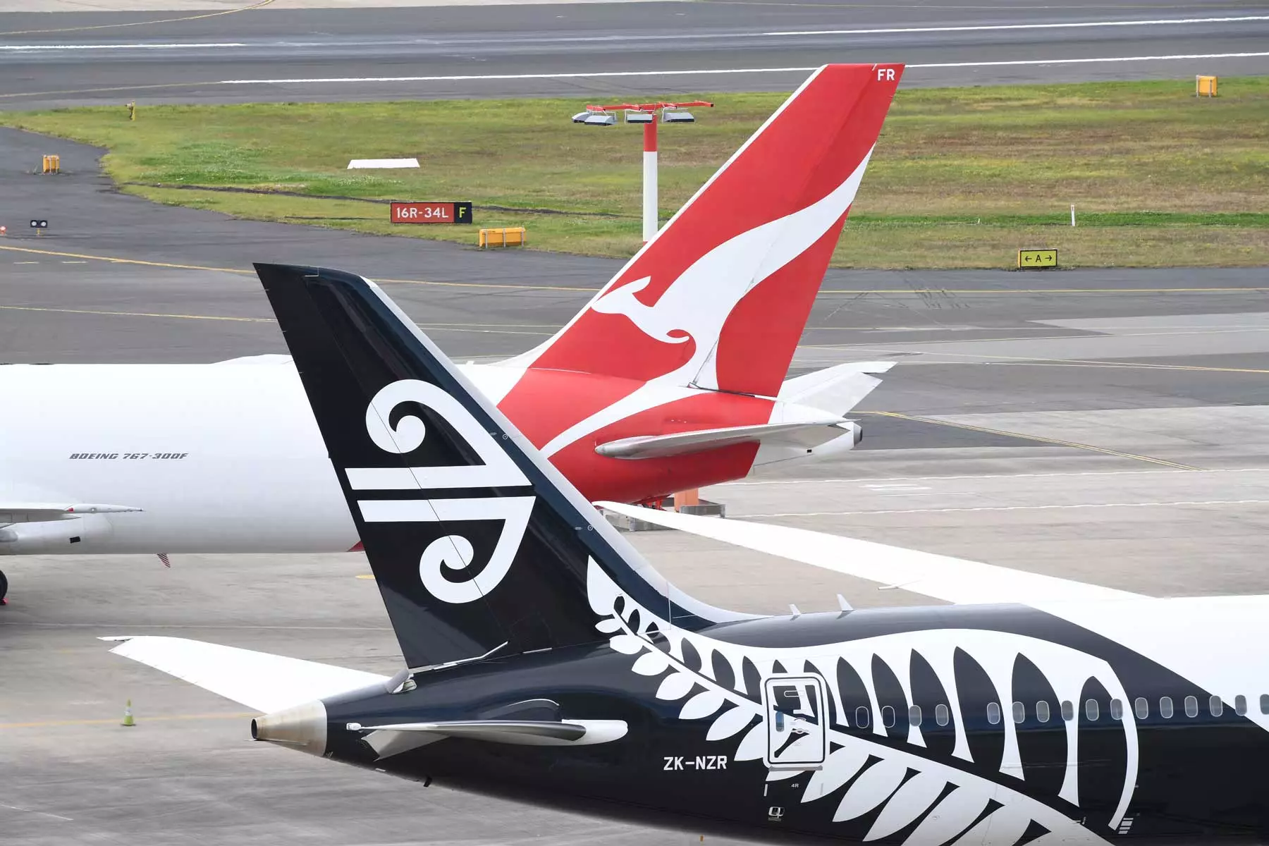 Sebuah pesawat Air New Zealand dan sebuah pesawat Qantas di apron kedatangan di bandara Internasional Kingsford Smith pada 26 Juli 2021 di Sydney, Australia.