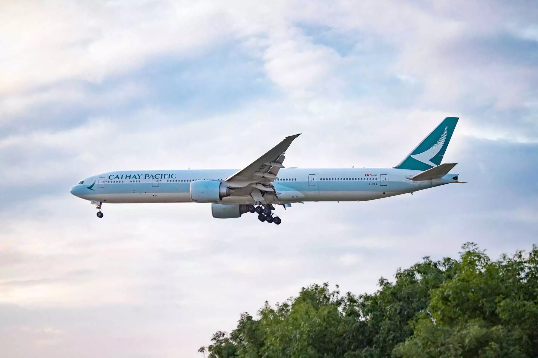 „Cathay Pacific Boeing 777“ orlaivis, skrendantis ir besileidžiantis prie šiaurinio Londono Hitrou tarptautinio oro uosto LHR EGLL kilimo ir tūpimo tako Anglijoje, JK.