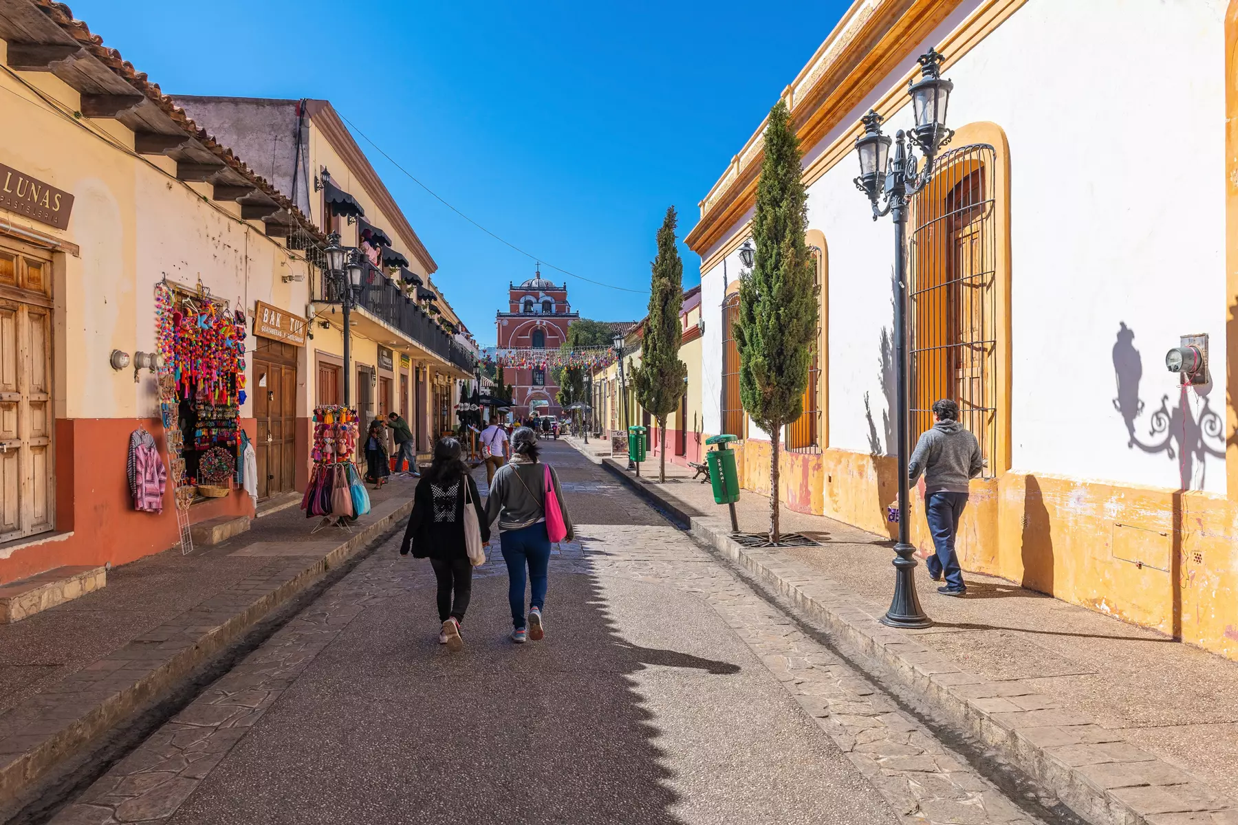 Menschen, die in einer farbenfrohen Straße im mexikanischen Kolonialstil in der Innenstadt von San Cristobal de las Casas, Bundesstaat Chiapas, Mexiko, spazieren gehen.