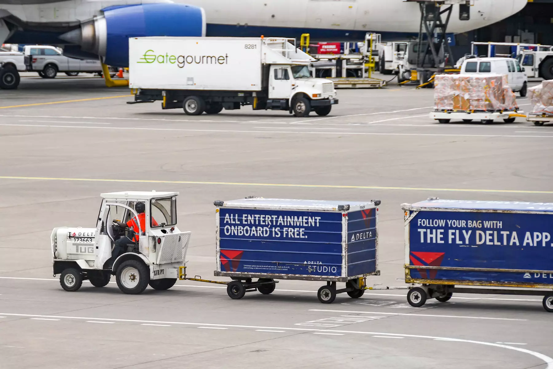 Pequena unidade de trator puxando caminhões de bagagem da Delta Air Lines no aeroporto de Seattle Tacoma