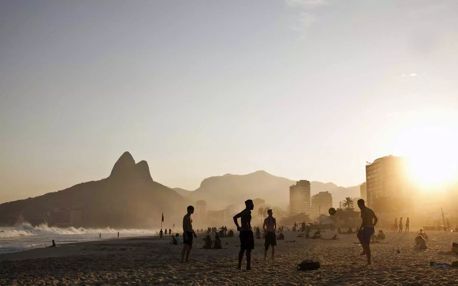 Fußball spielen bei Sonnenuntergang am Strand von Ipanema, Rio de Janeiro, Brasilien